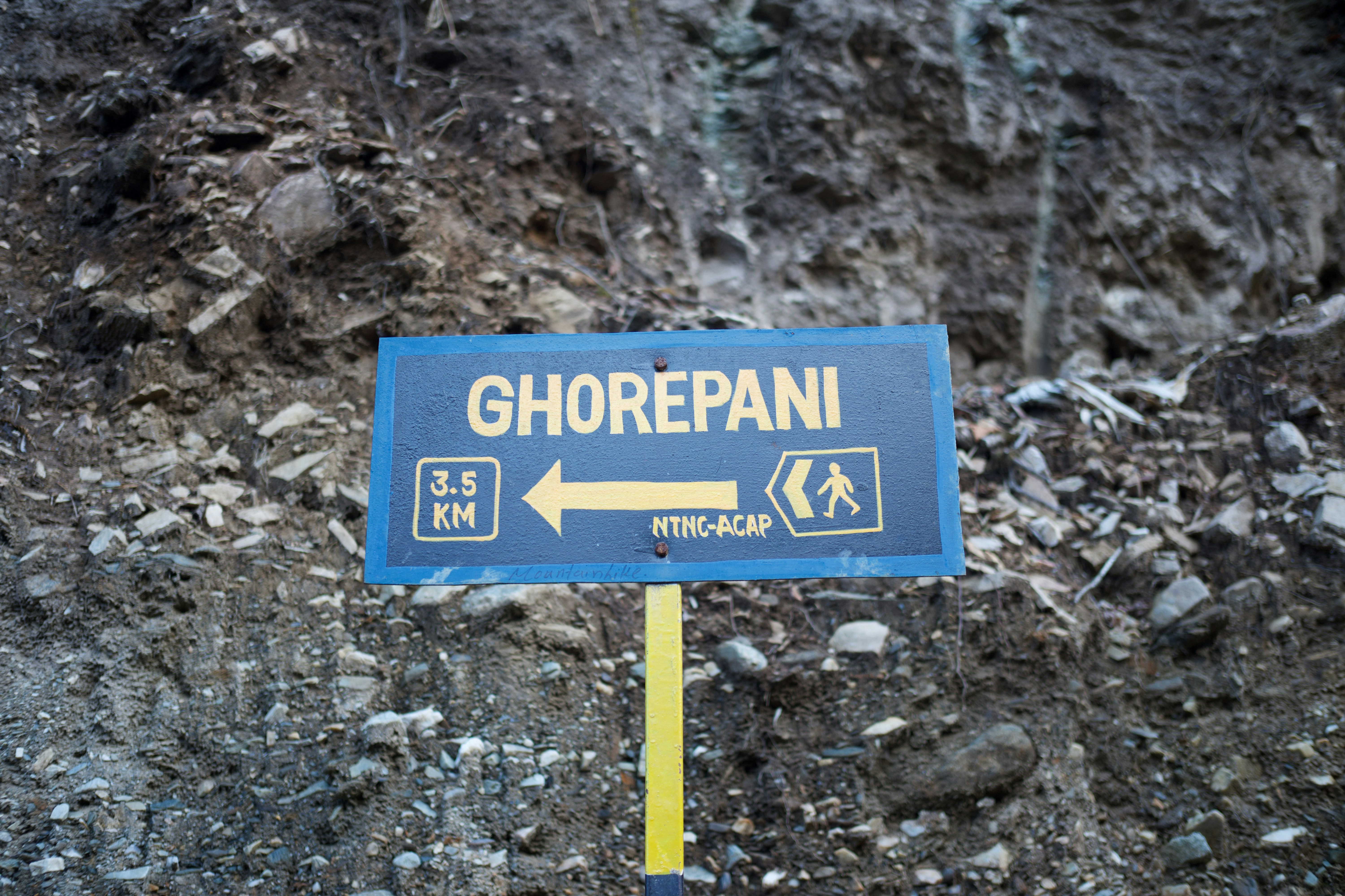 Blue Trail Sign Pointing the Way Through Rocky Terrain