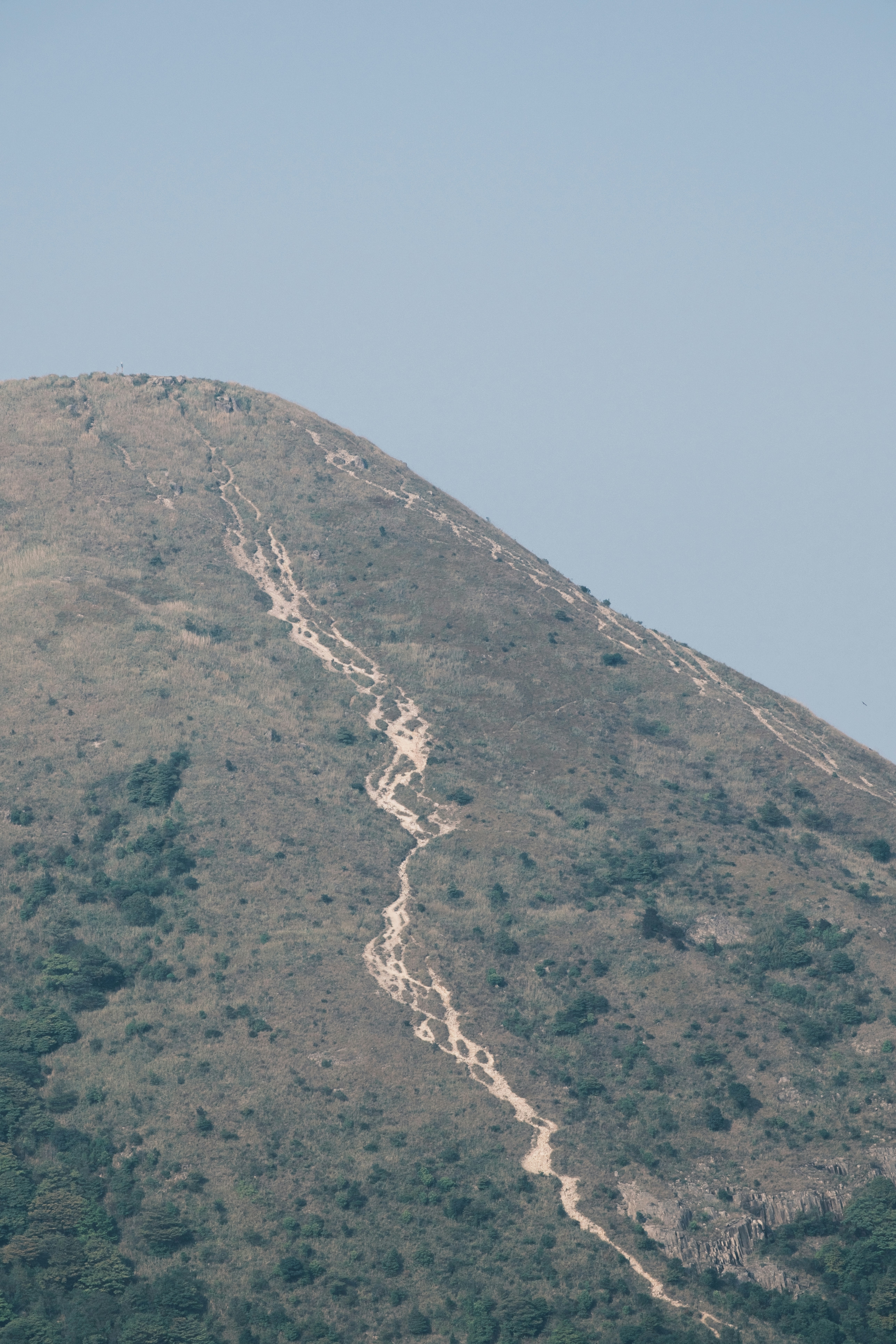 Trail Snaking Up the Mountain: A Quiet Traverse Against a Clear Sky