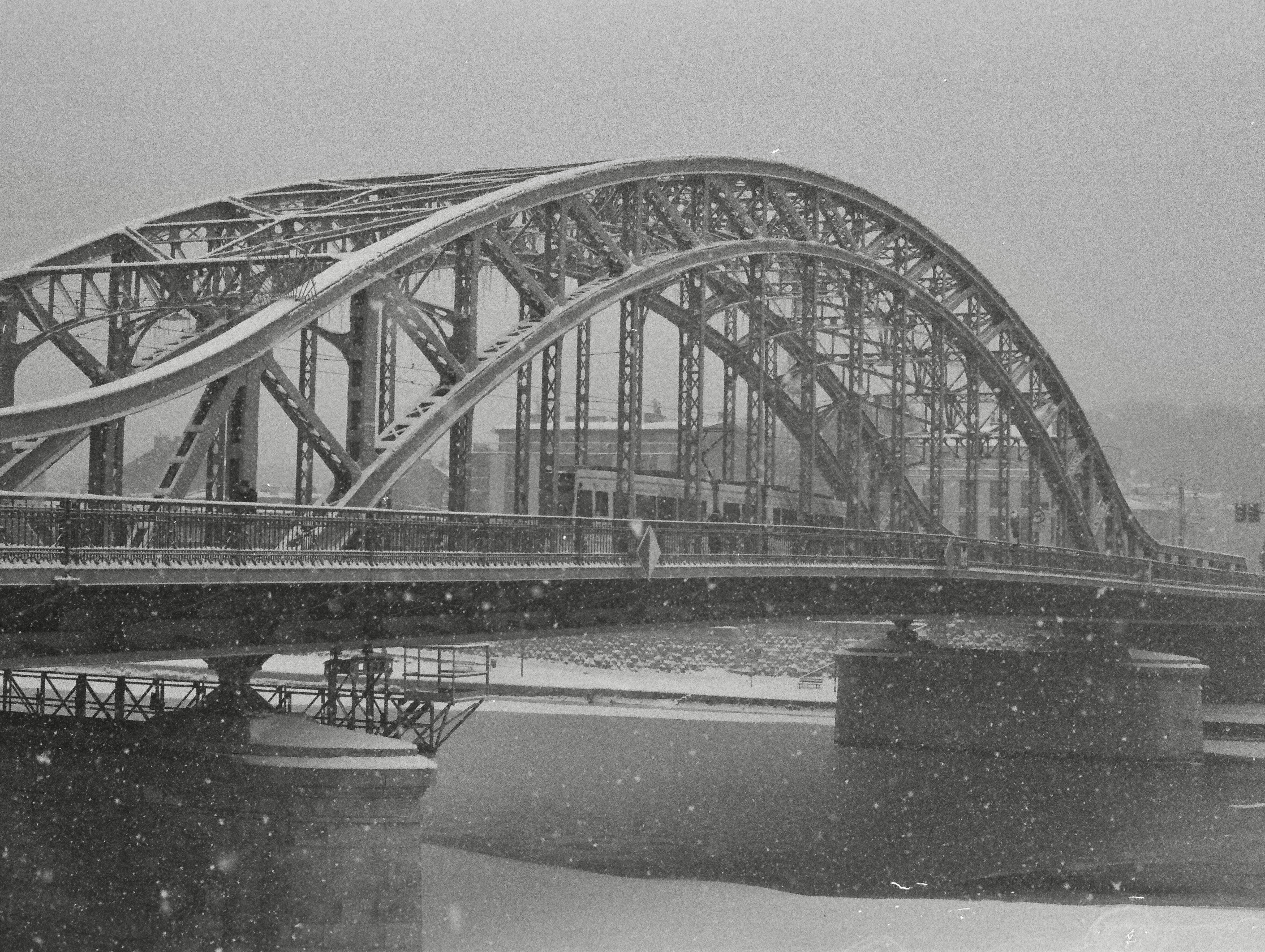A metal arch bridge spans a body of water