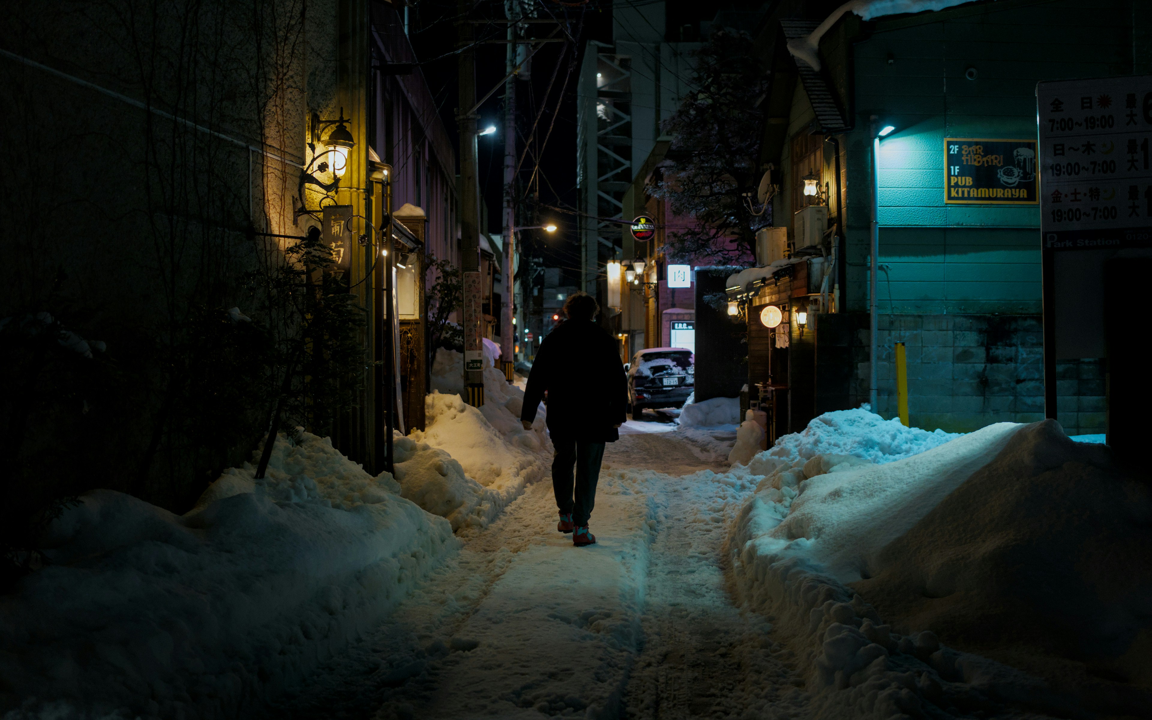 Midnight Snowpalace: A lone figure in a moonlit alley