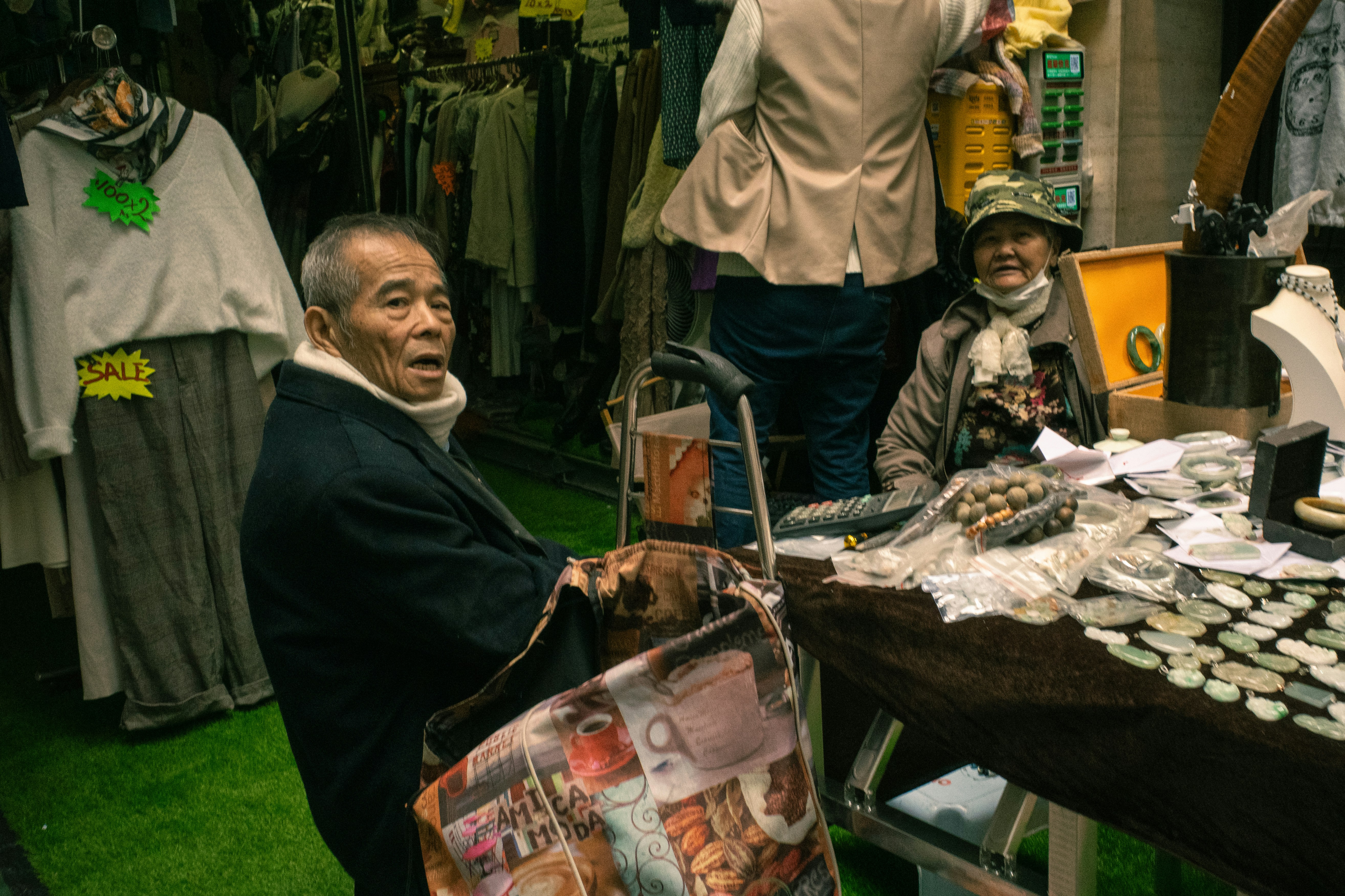 Street Stall Vigil: A Mall Tête-à-Tête Between Elder Figures