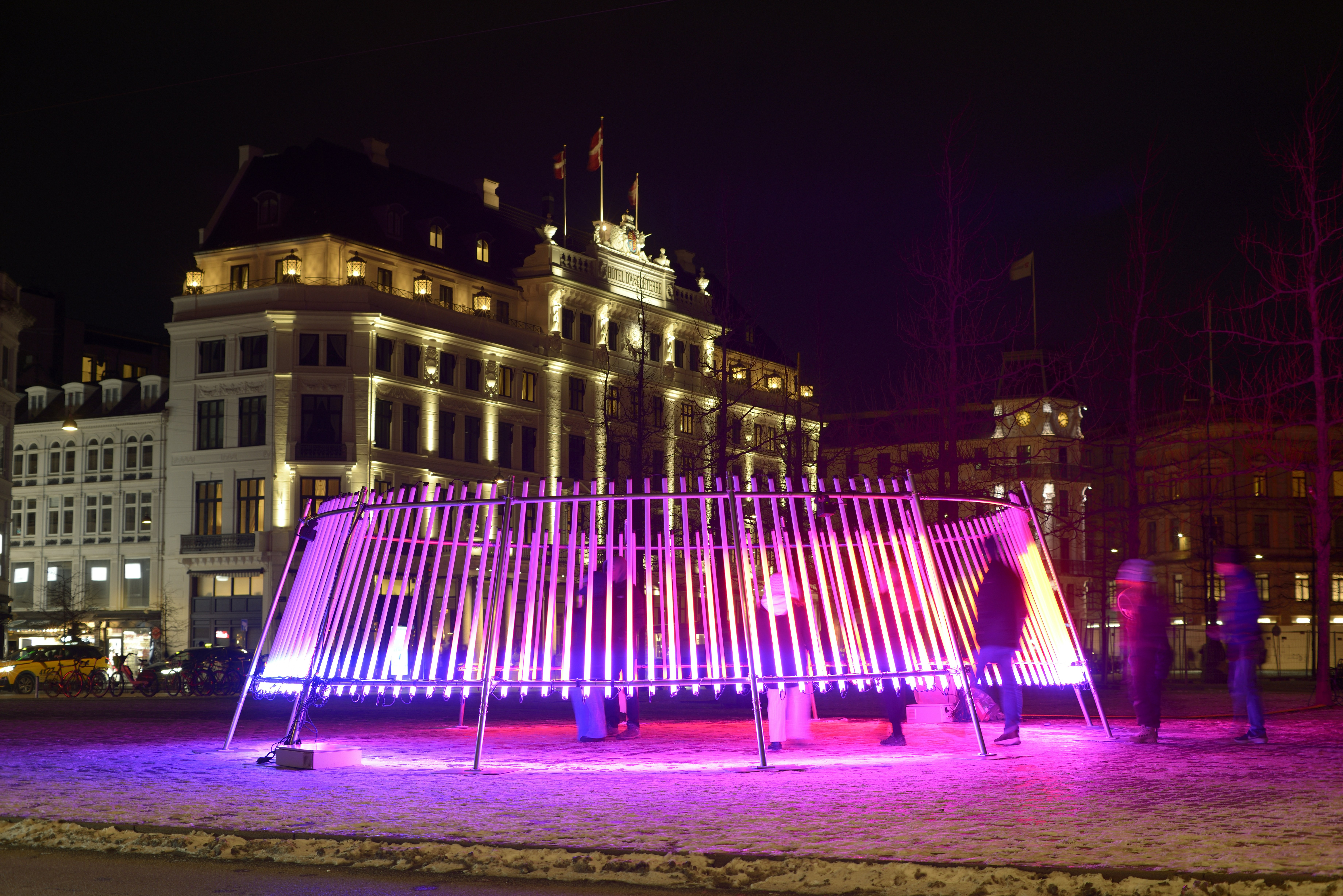 Neon Curtain in the City Night: A Framed Light Sculpture Beside Historic Facades