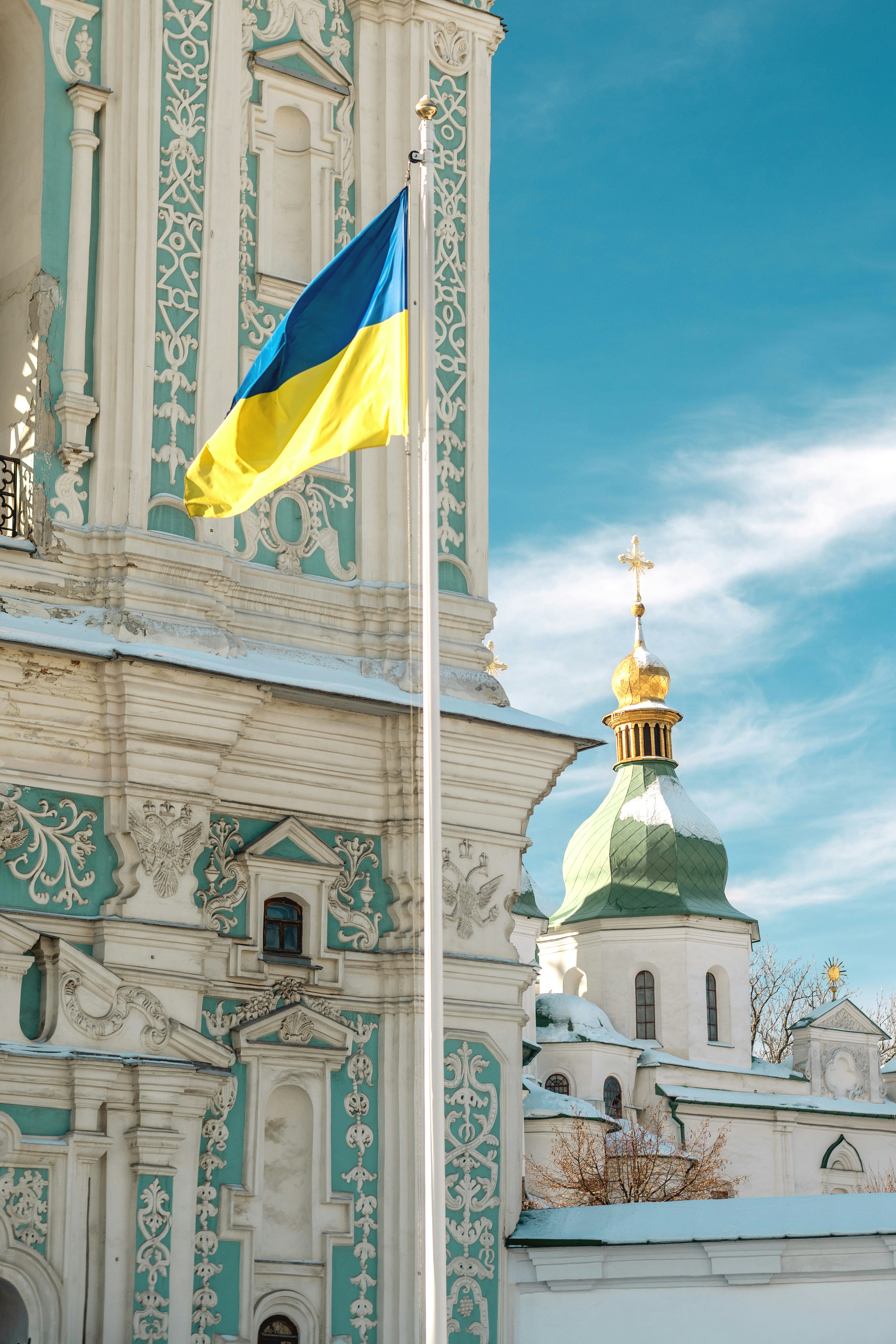 Flag Over Ornate Facade: Ukrainian National Colors Against Blue Sky