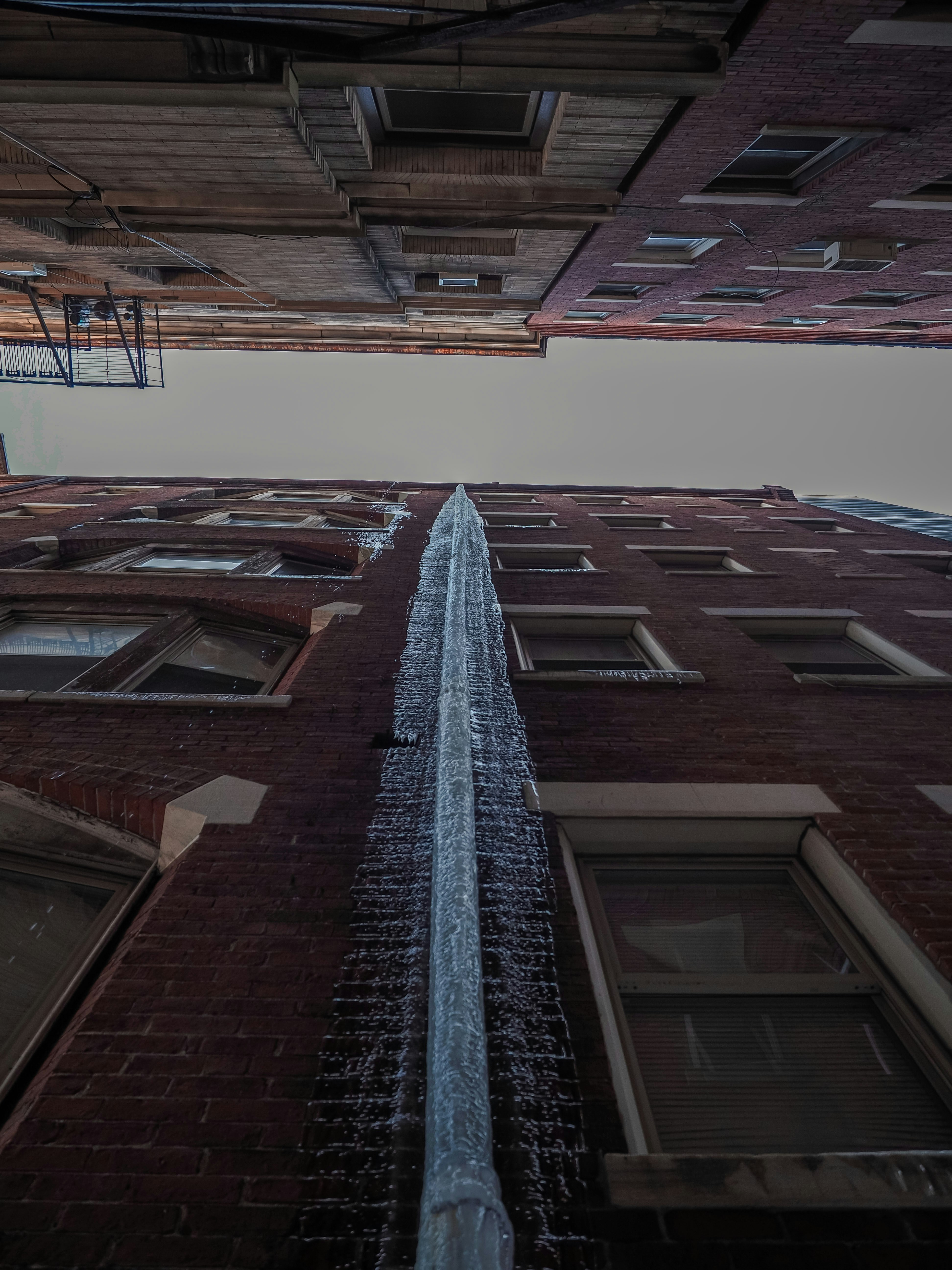 Vertical Icefall Between Brick Facades