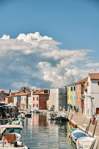 Pastel Canalfront: Boats and Townhouses Reflecting in a Pedestrian‑lined Sponda Channel