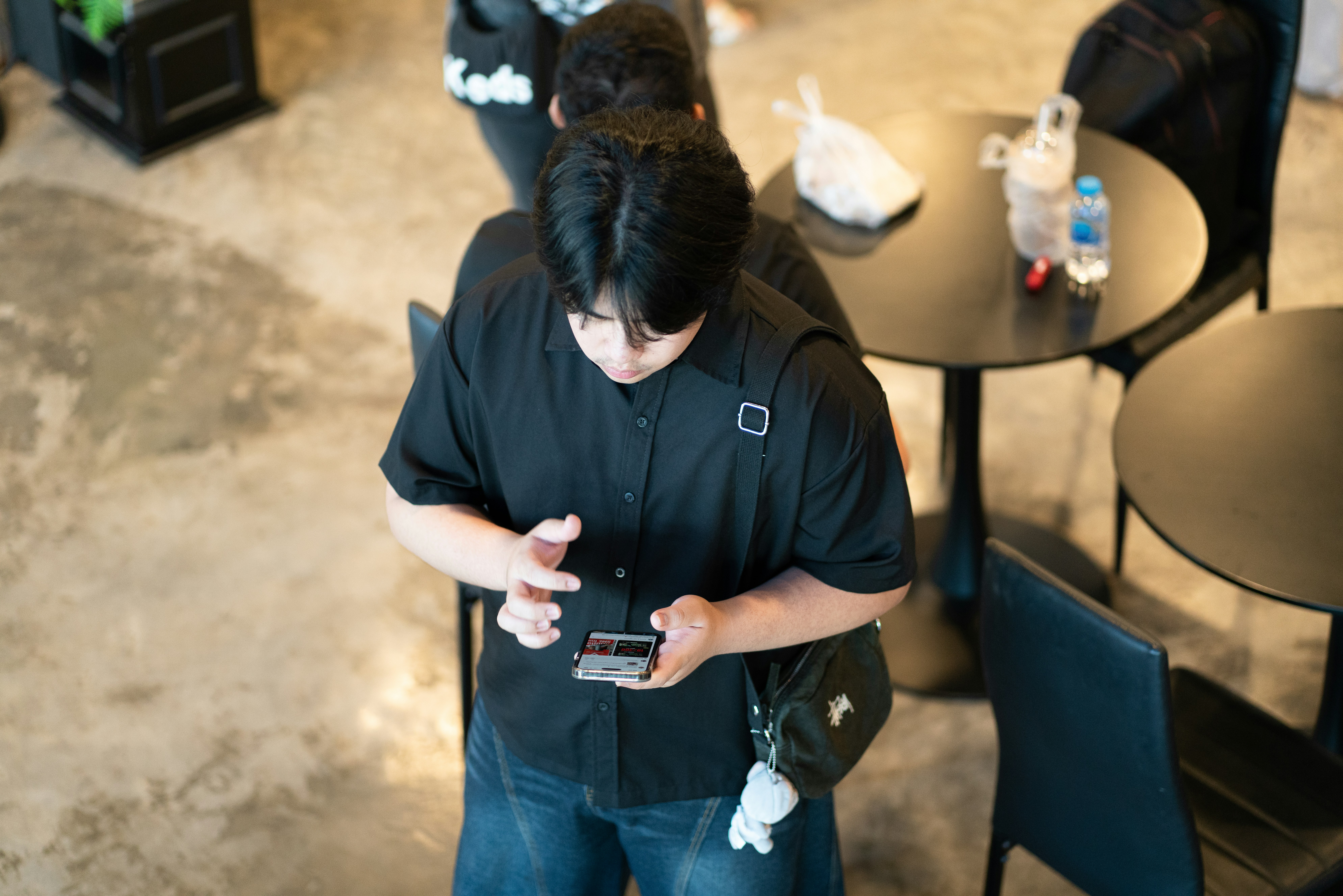Portrait of a Tech-Savvy Moment: Looking at the Phone in a Café Setting
