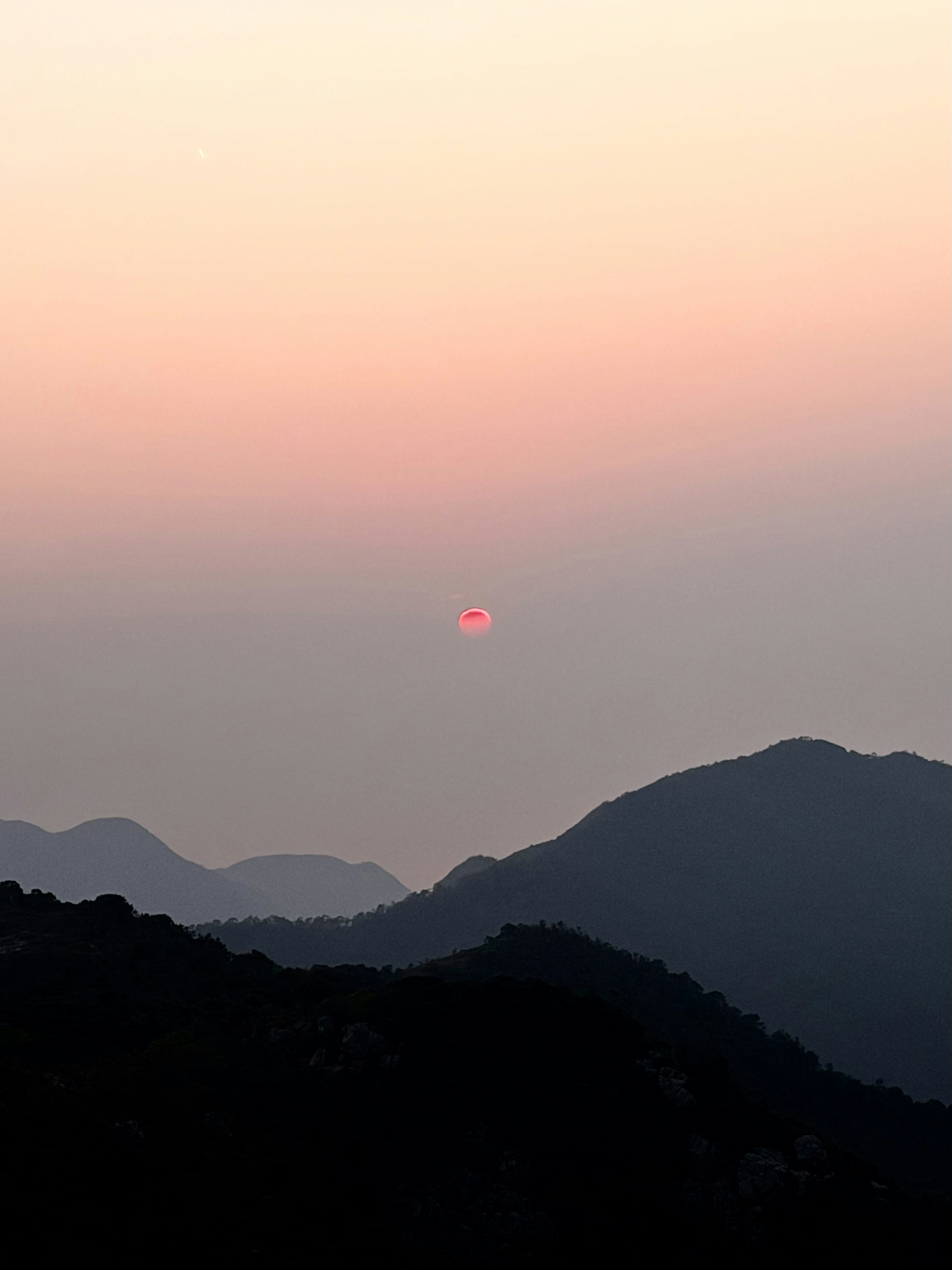 Red Sun Halftime Over Distant Ridges at Dusk