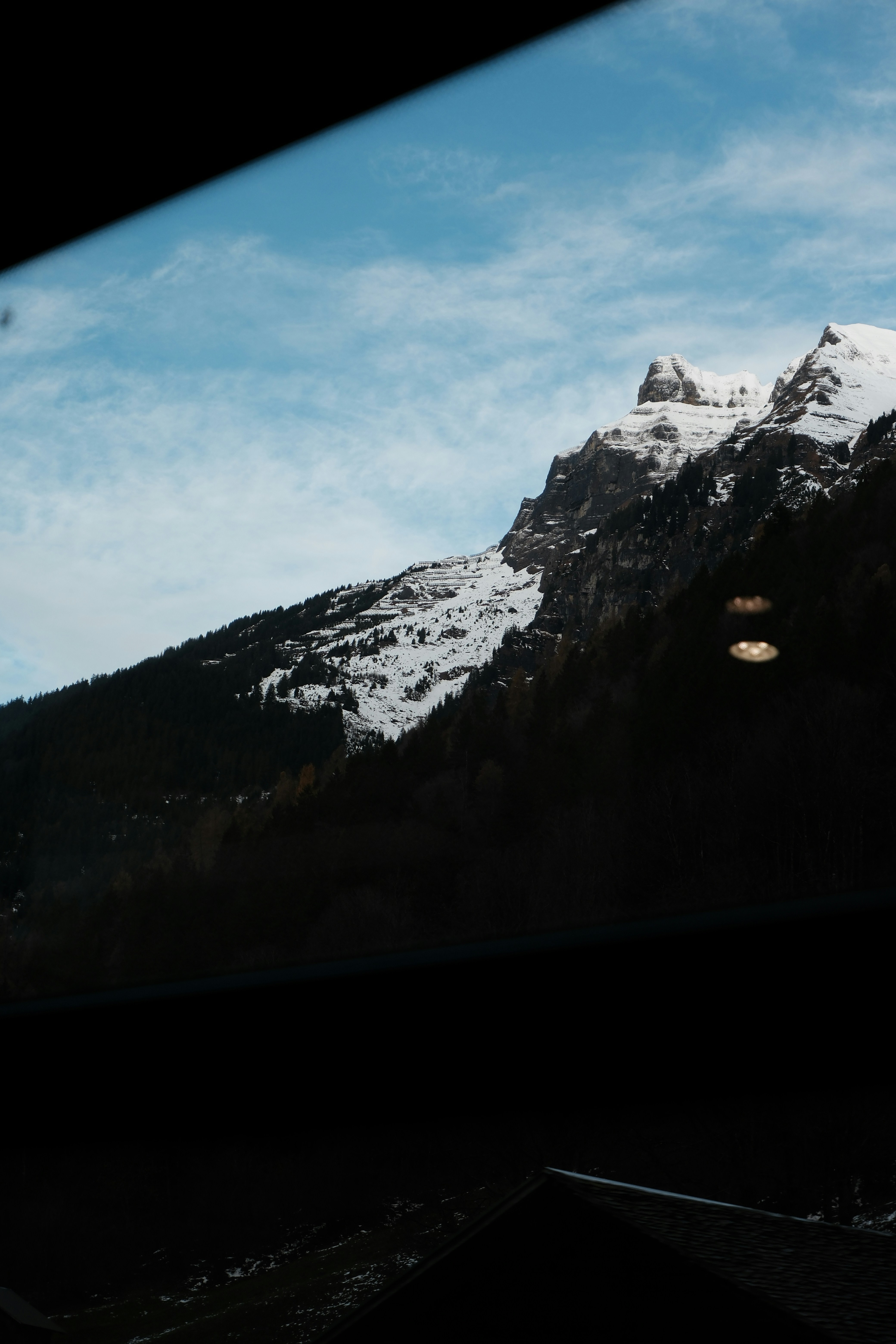 Snow-Capped Peak Framed by Dark Window Edges
