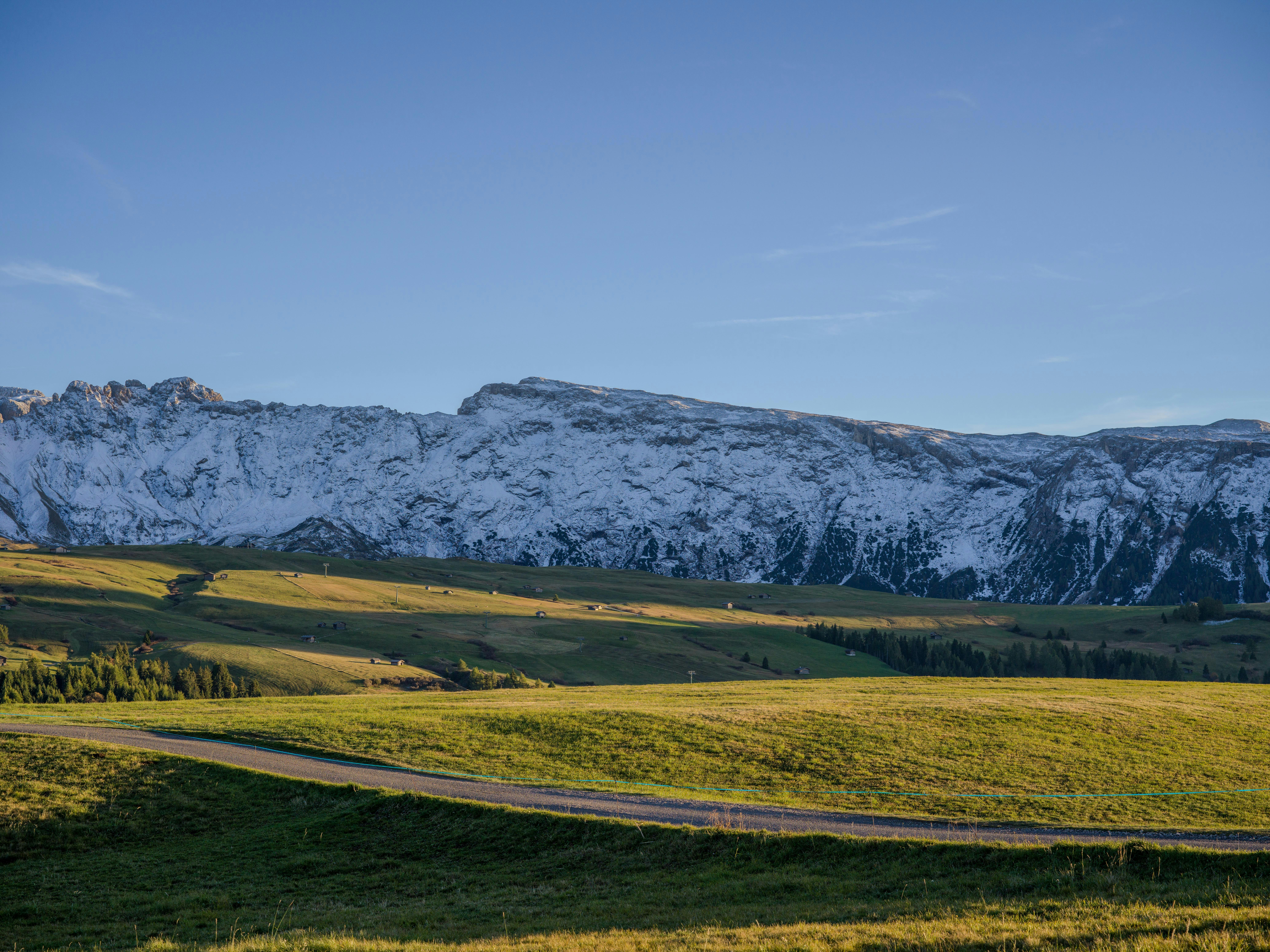 Snow-dusted Ridge Over Rolling Valleys Under a Clear Blue Sky