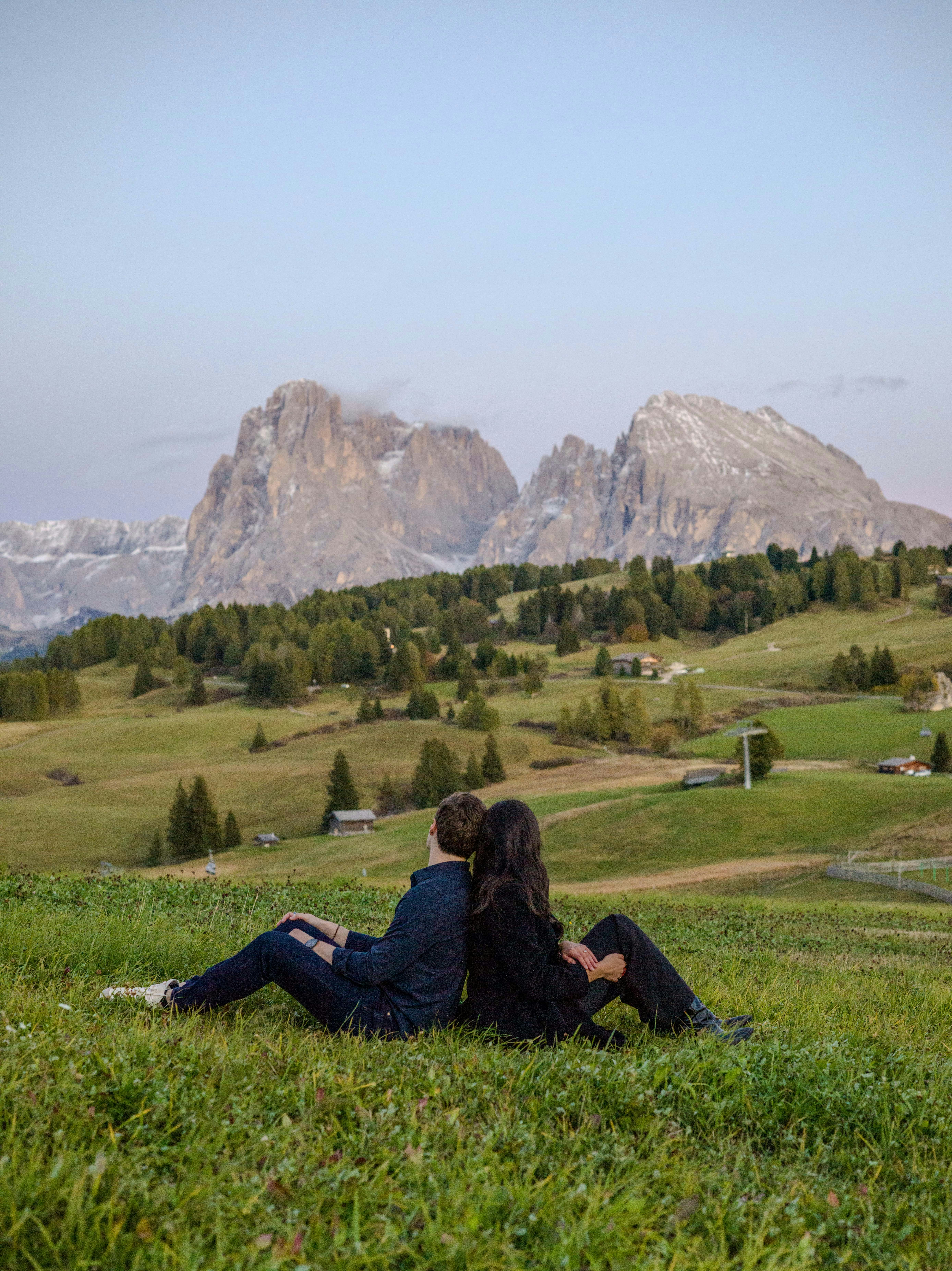 Couple in a valley embrace beneath rugged alpine peaks