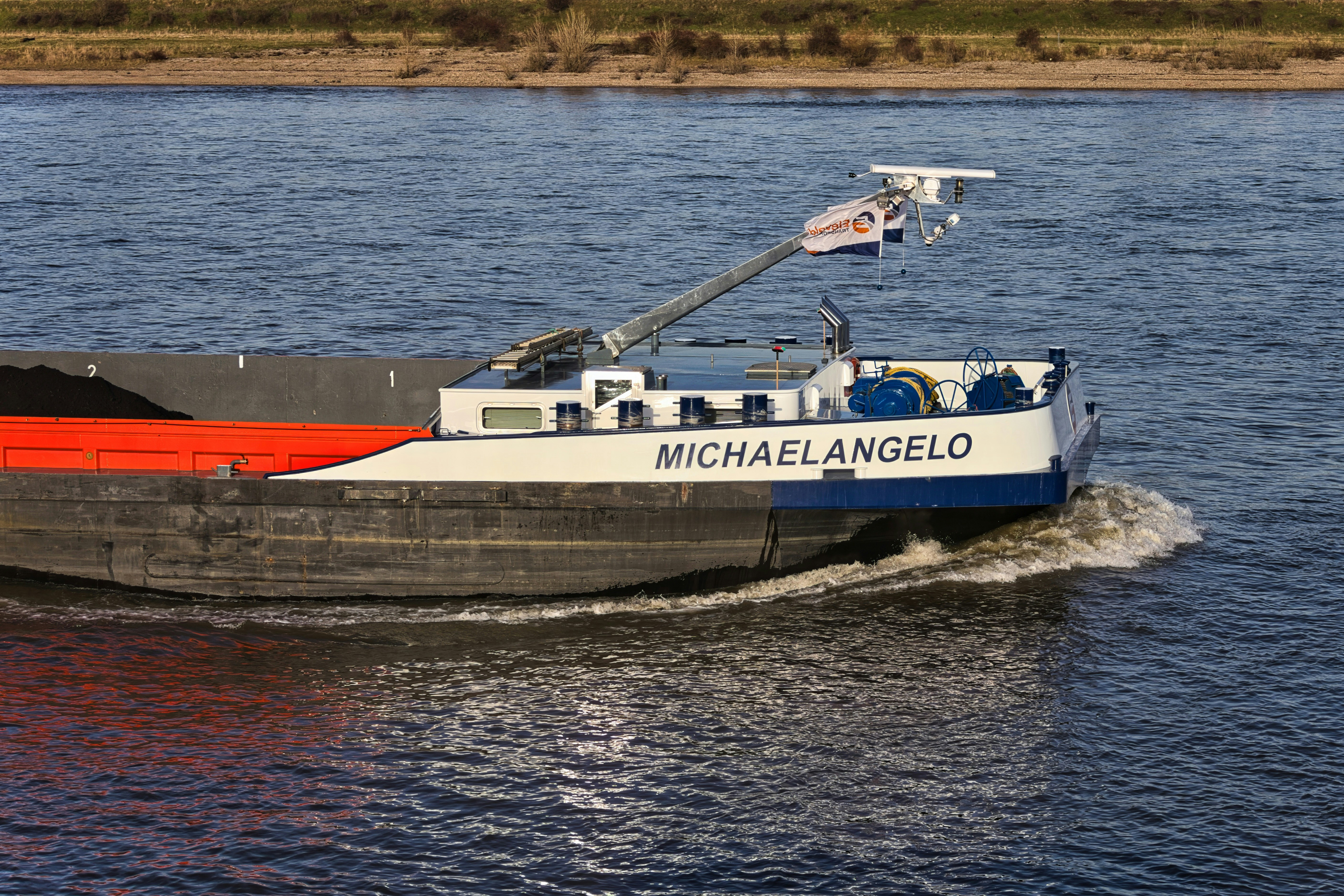 River Barge Michaelangelo Gliding Past the Shore