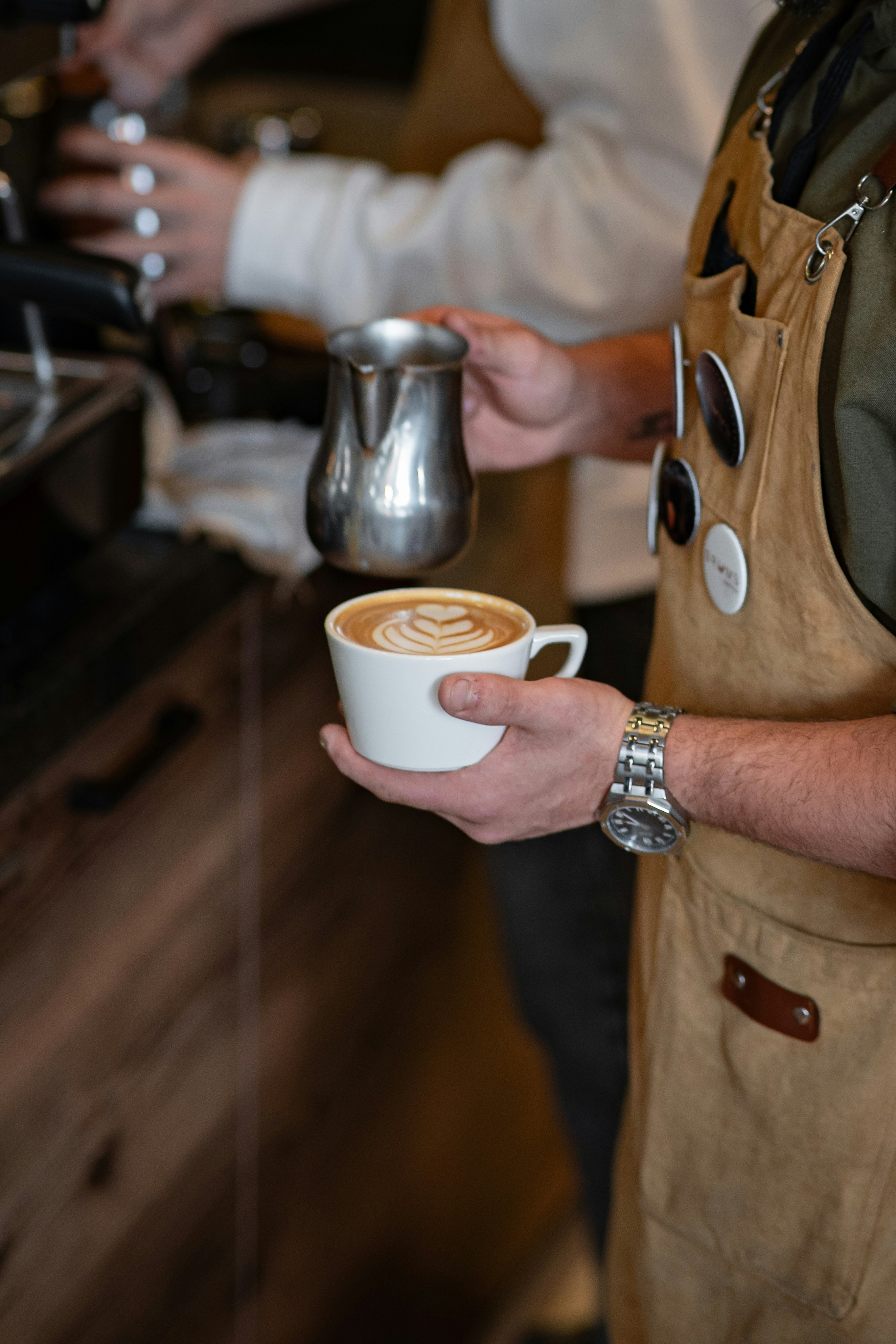 Barista at Work: Foam Art and Coffee Pour in Focus