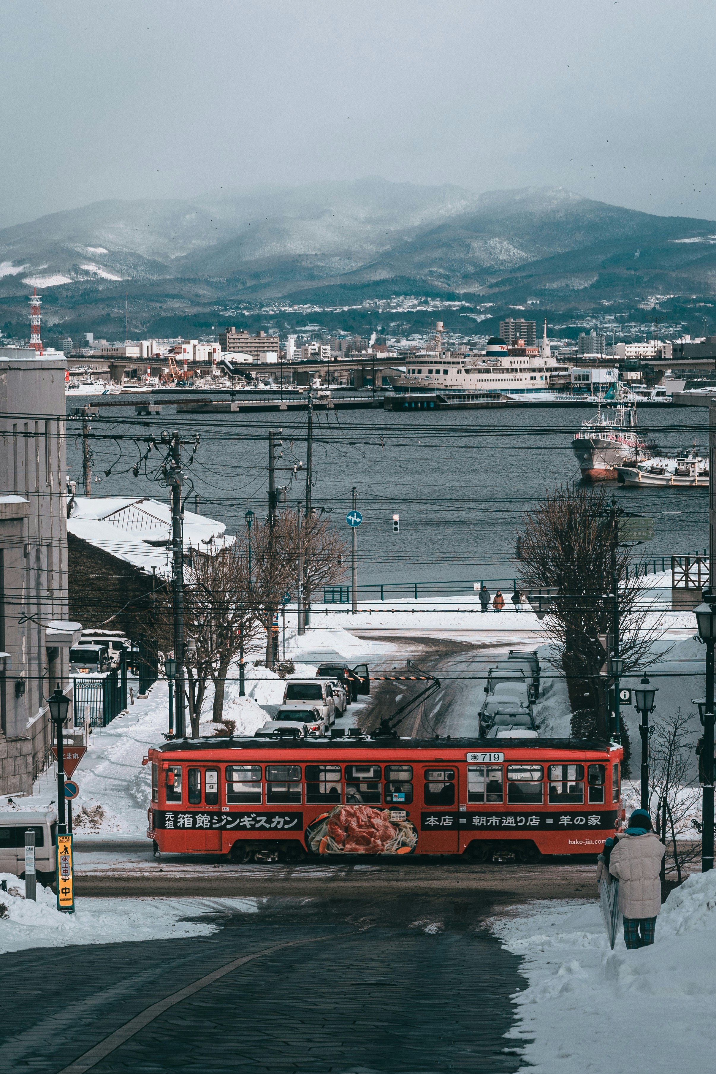 Snowy quay and red tram dusk: a wintry harbor scene
