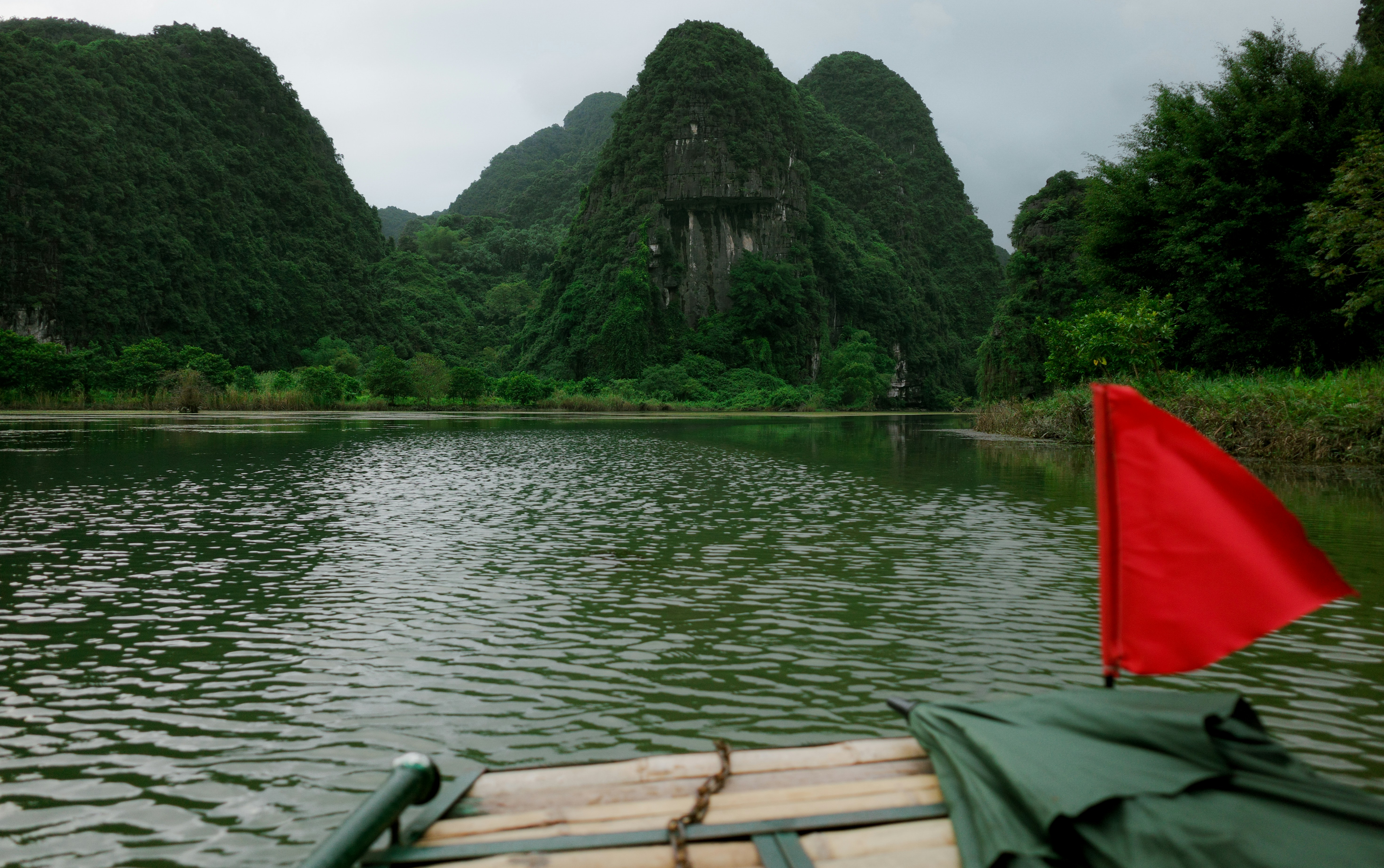 Red Flag on the Floating Boat against Limestone Peaks