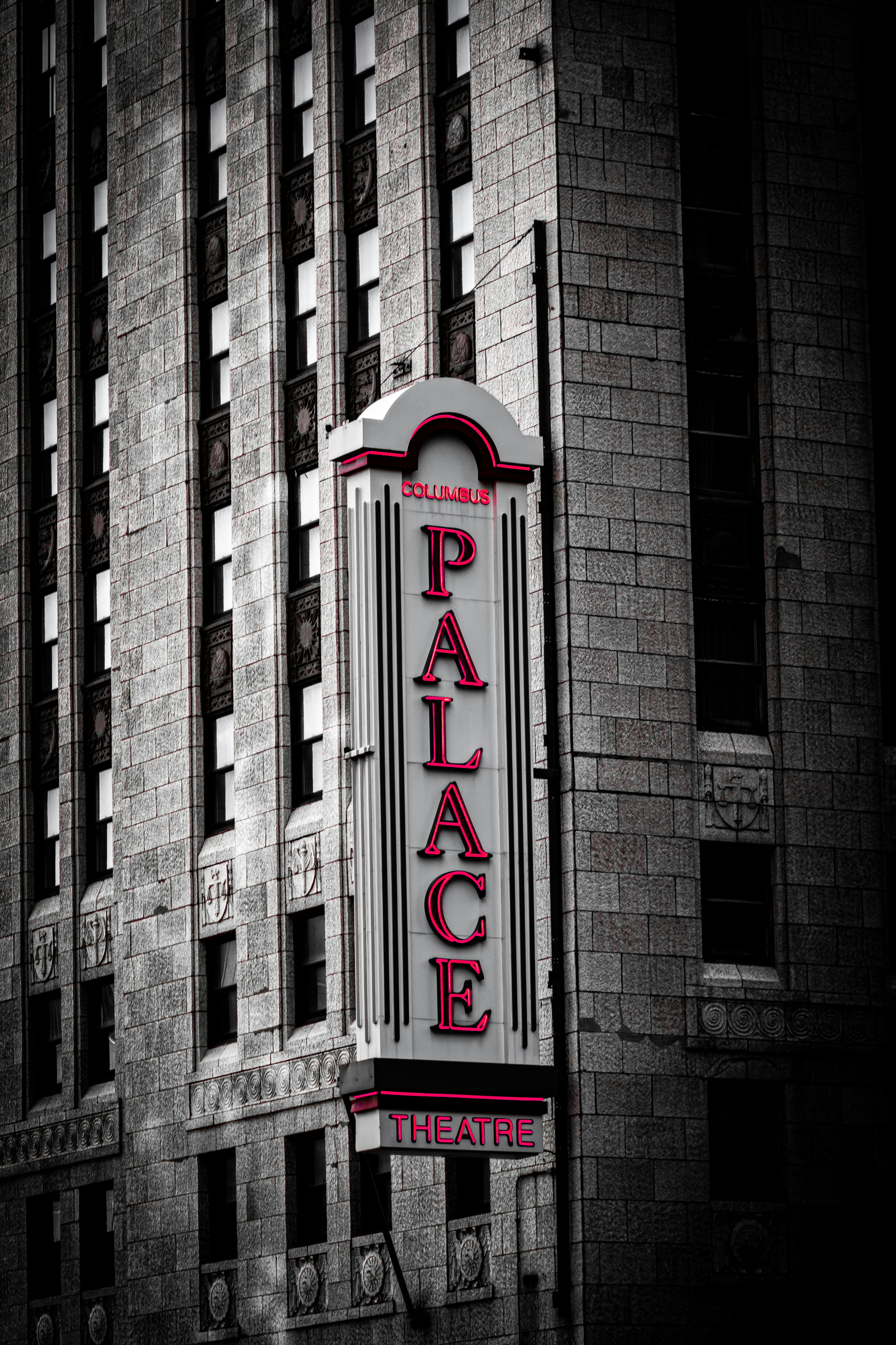 Neon Paladin: The Vertical Theatre Sign Anchoring a Monolithic Facade