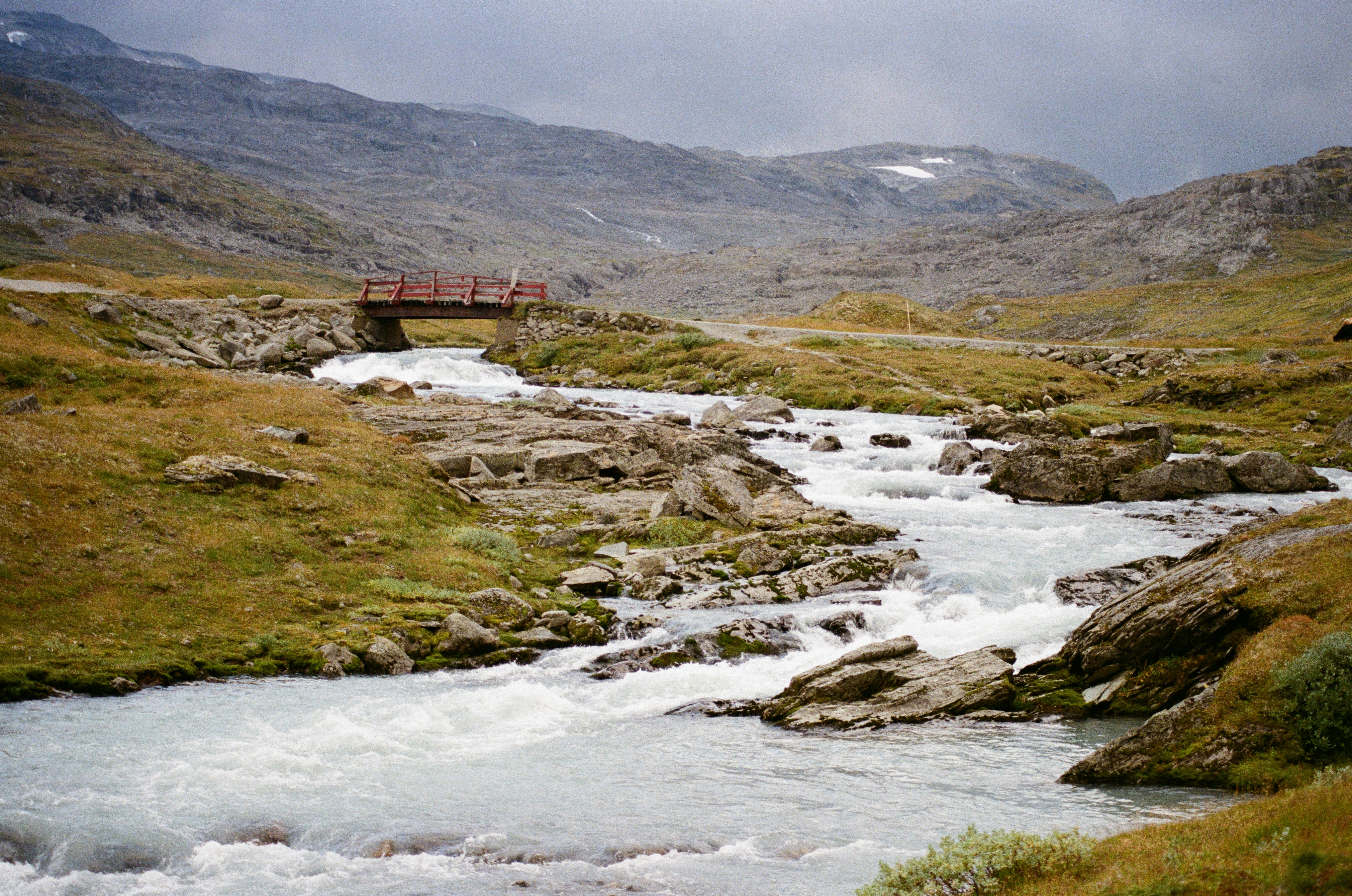River Crossing Under a Weathered Bridge in Alpine Moorland