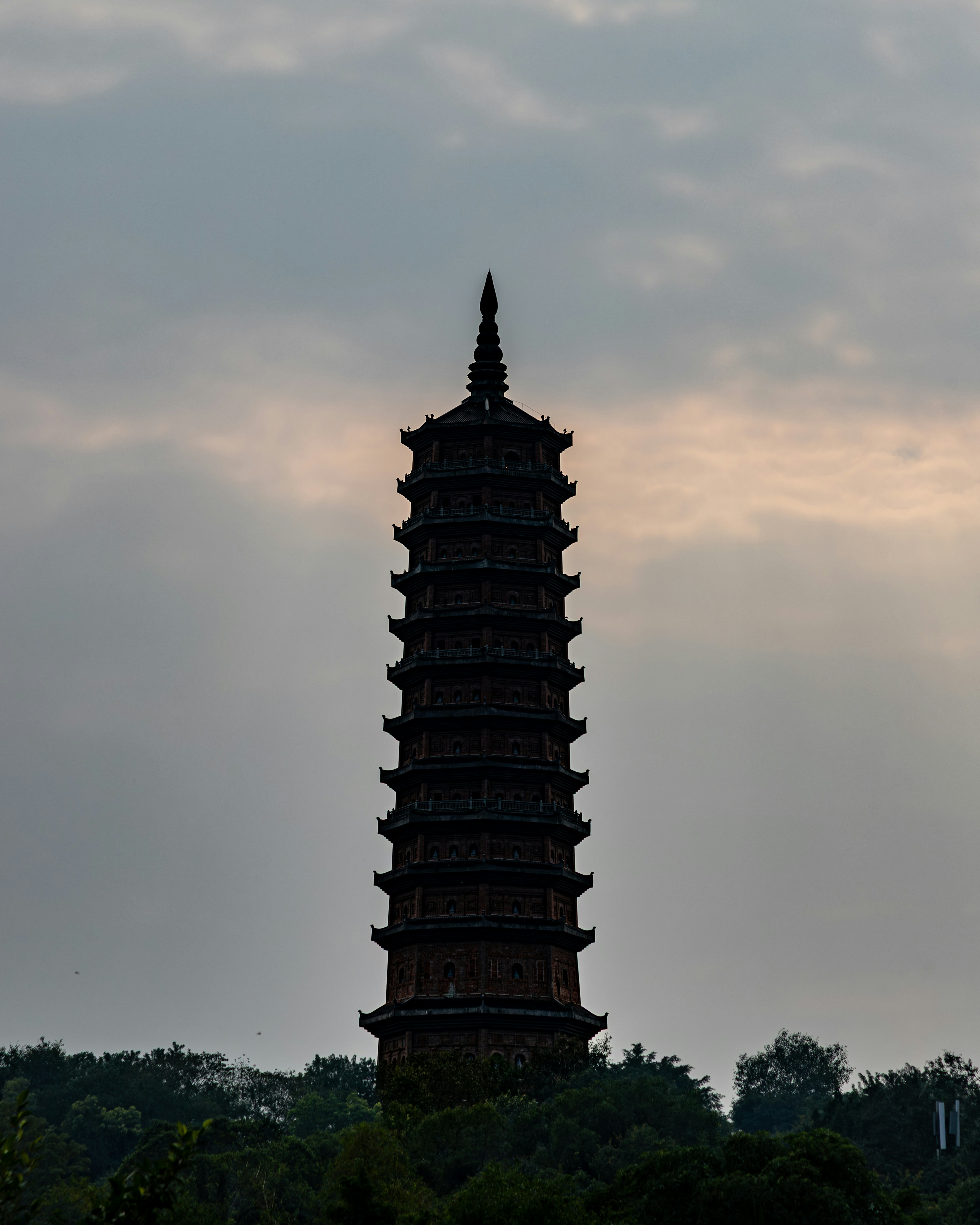 Silhouetted Pagoda Rising Above the Tree Line at Dusk