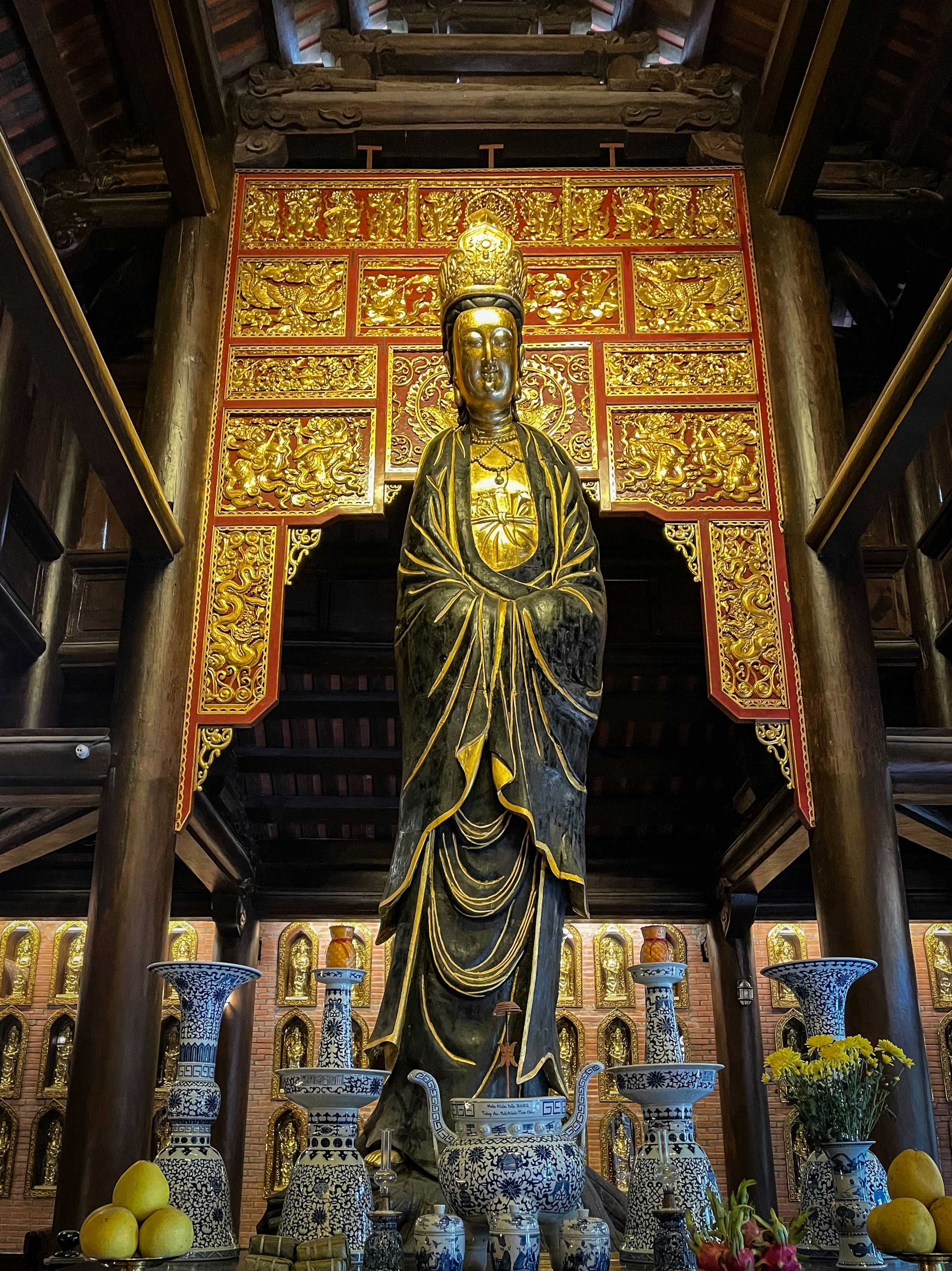 Golden Bodhisattva Under an Ornate Carved Altar