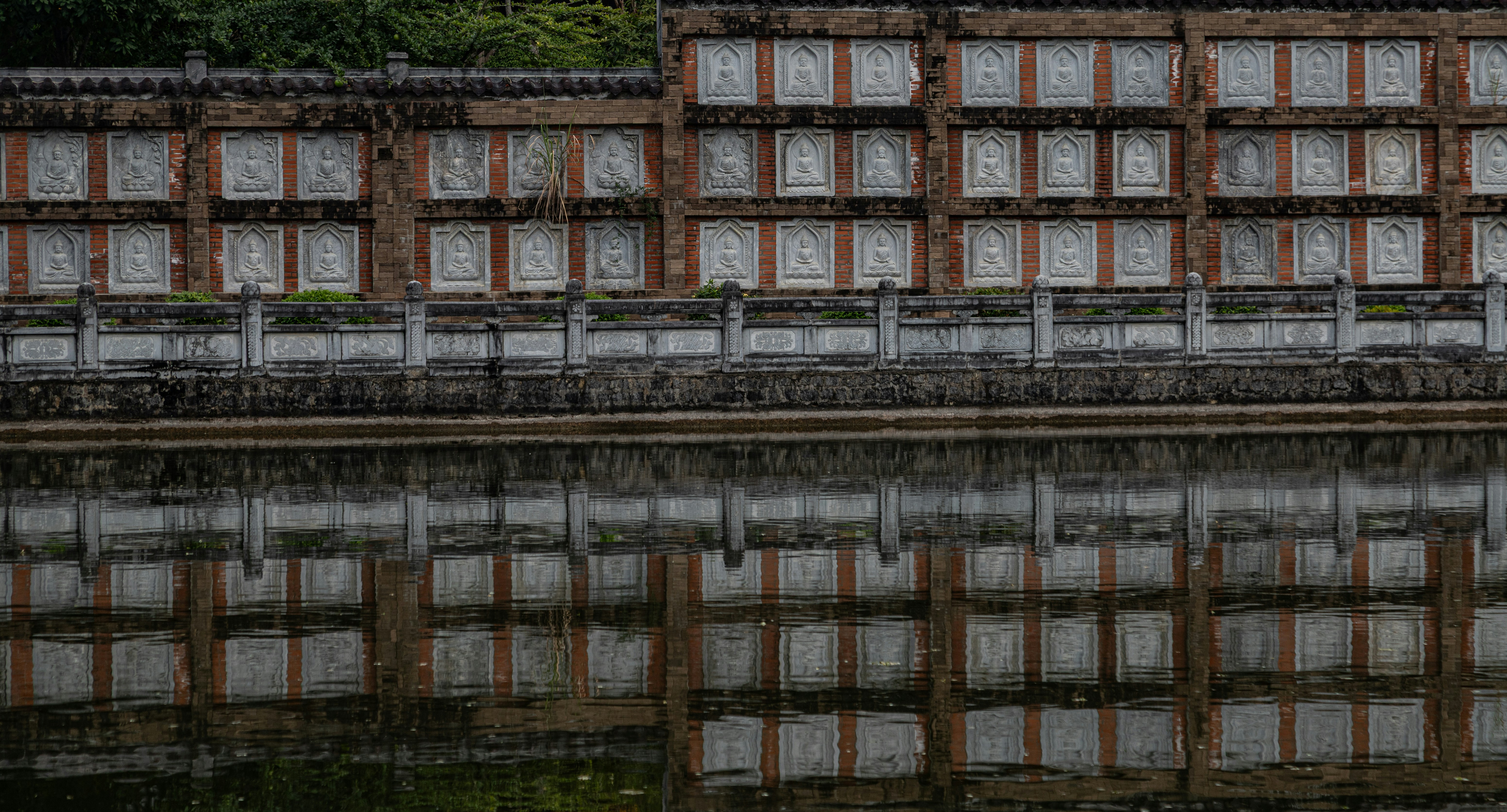 Reflections of a Stone Tapestry Along a Quiet Canal