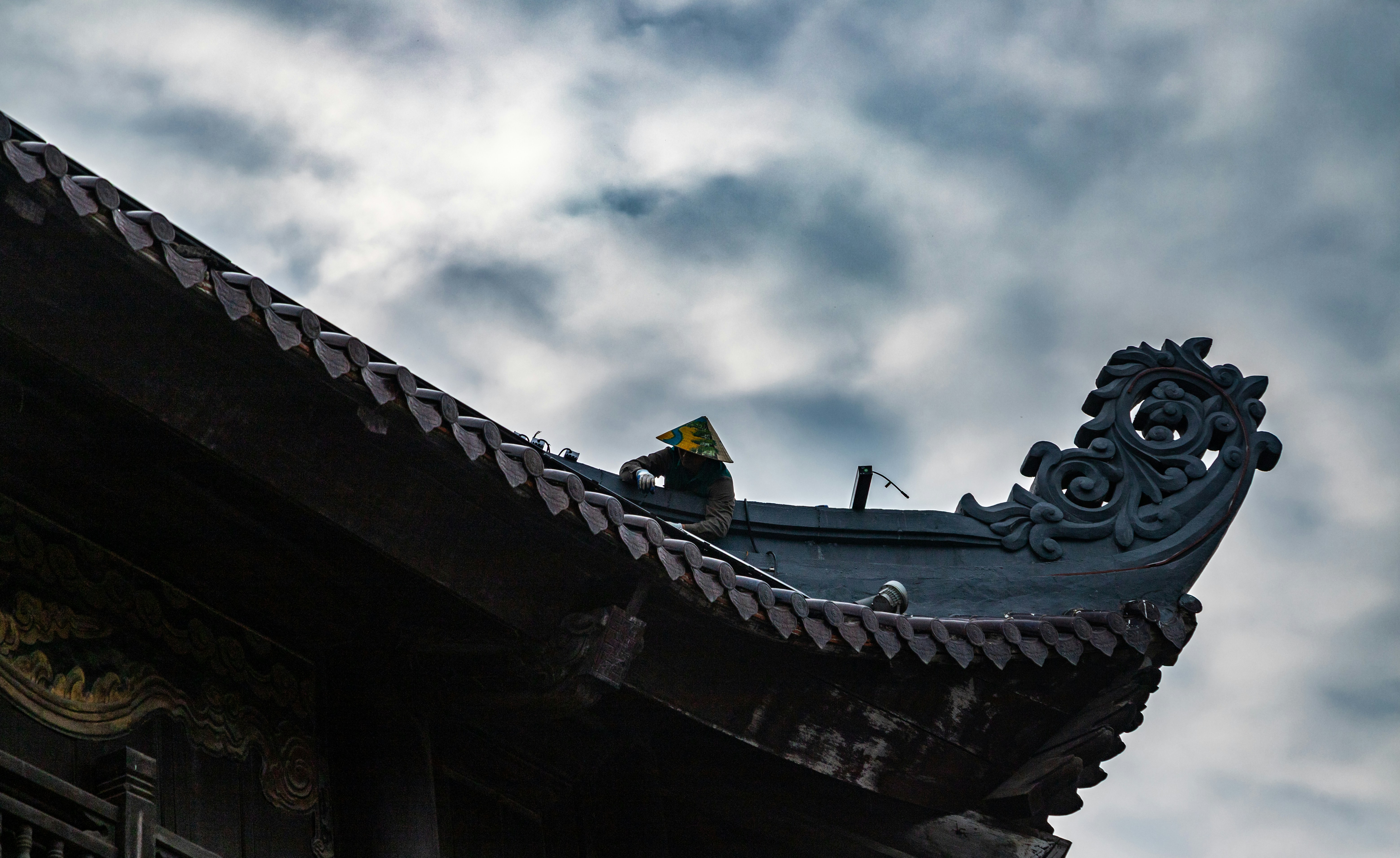 Dragon-Topped Roofline Under Clouded Sky