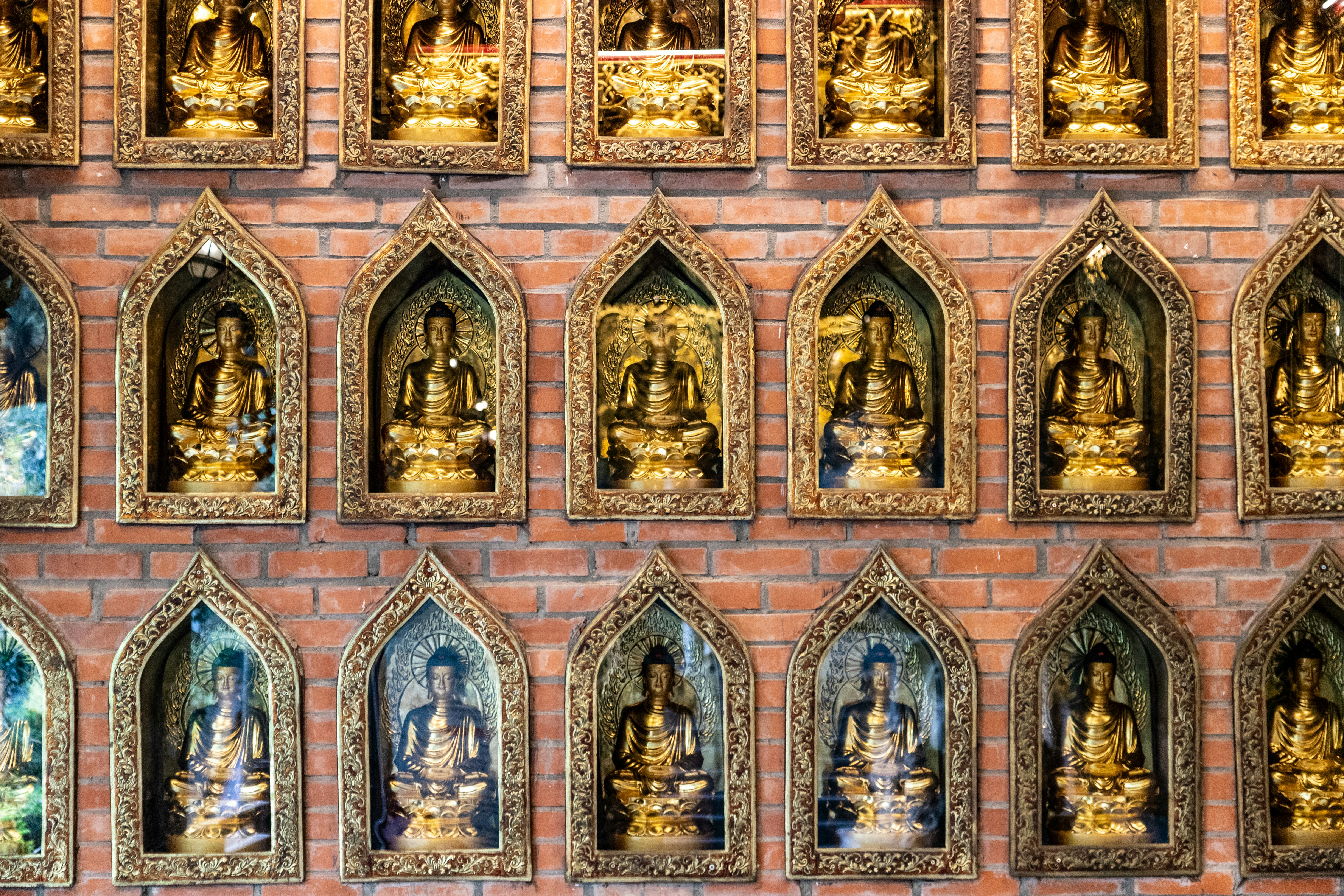 Rows of Golden Buddha Niches Framing a Brick-Walled Gallery
