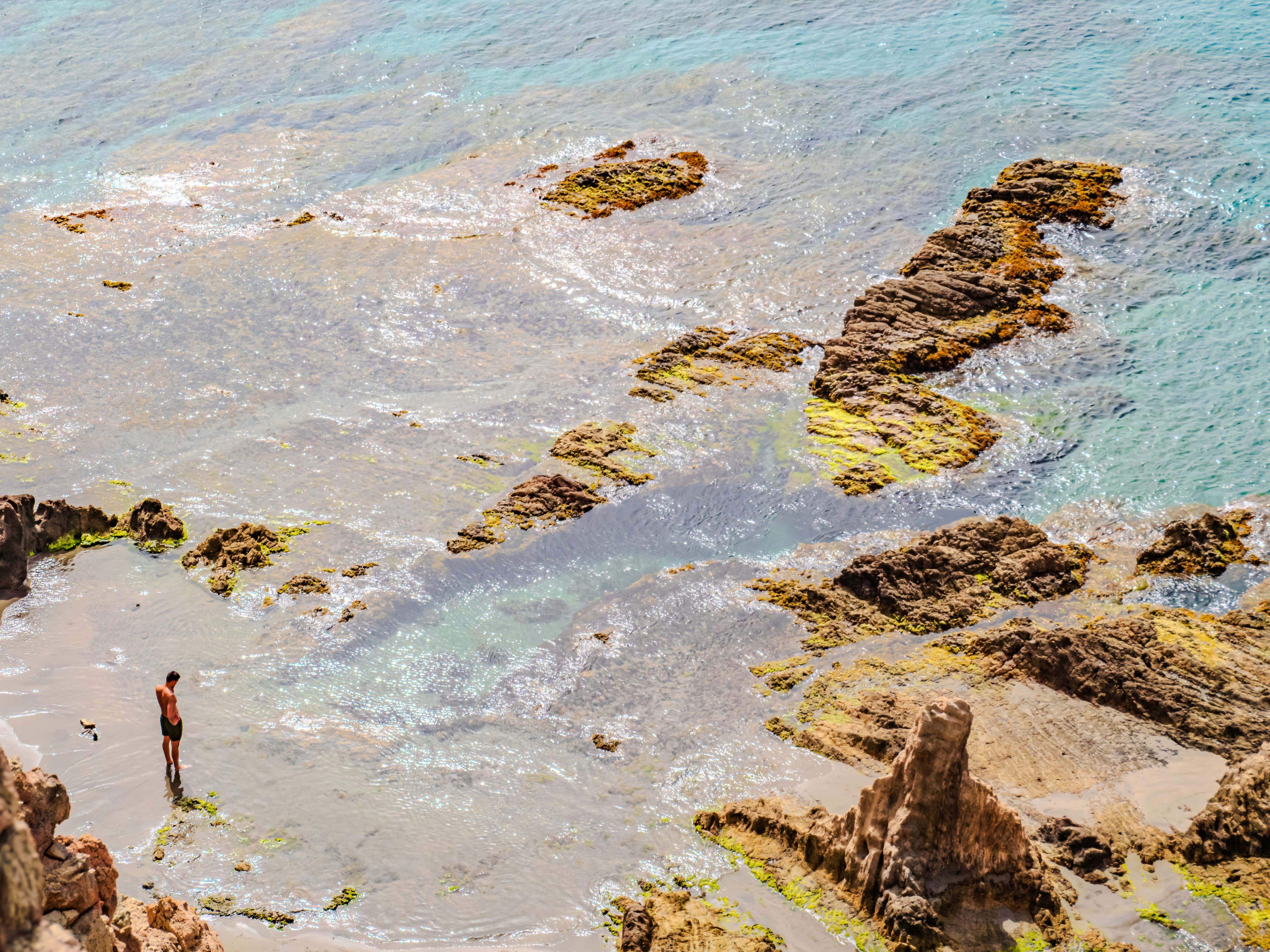 Solitary Figure Amid Tidal Steps: A Rooftop of Turquoise and Gray