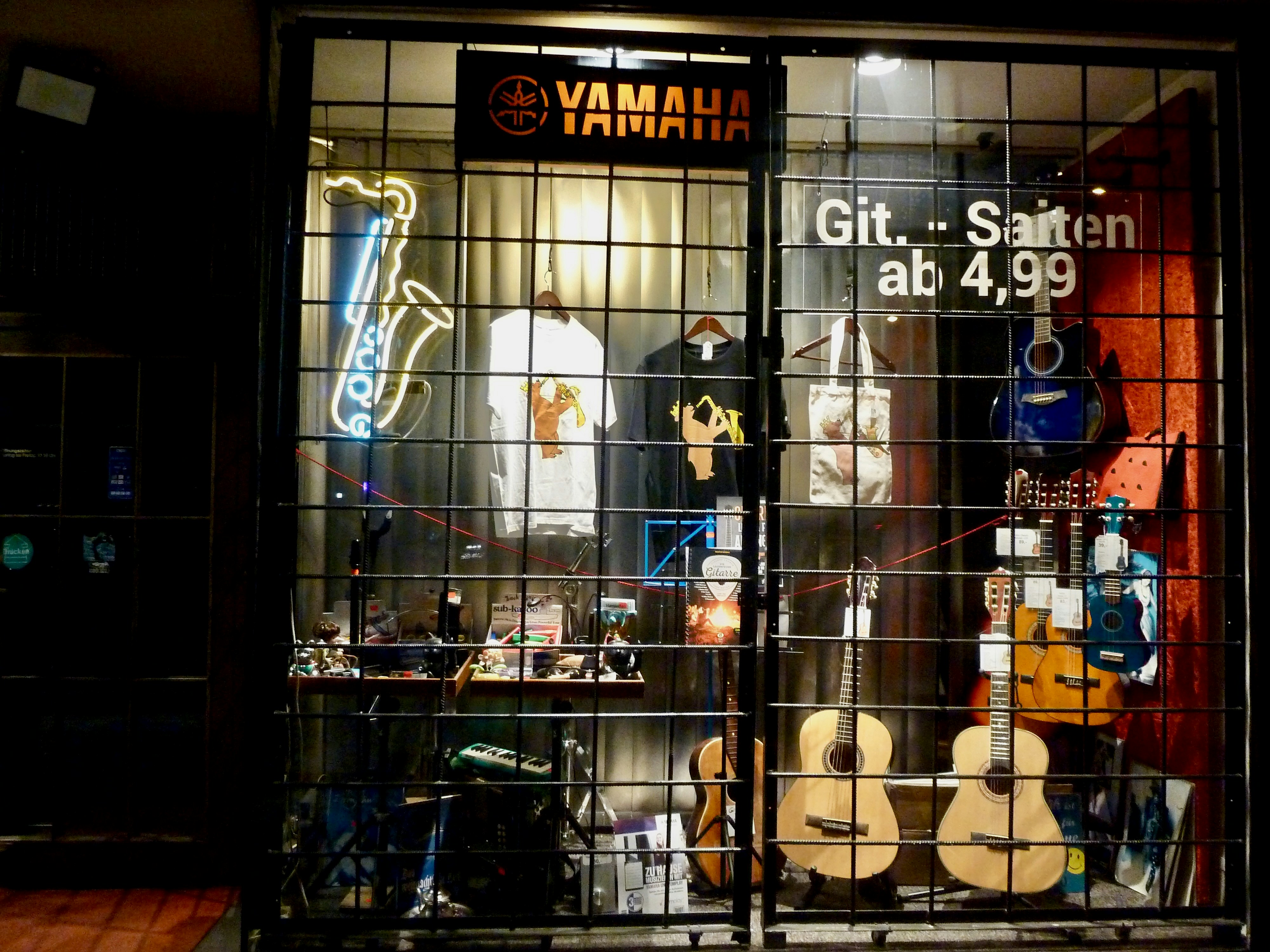Musical instruments and apparel displayed in a store window.