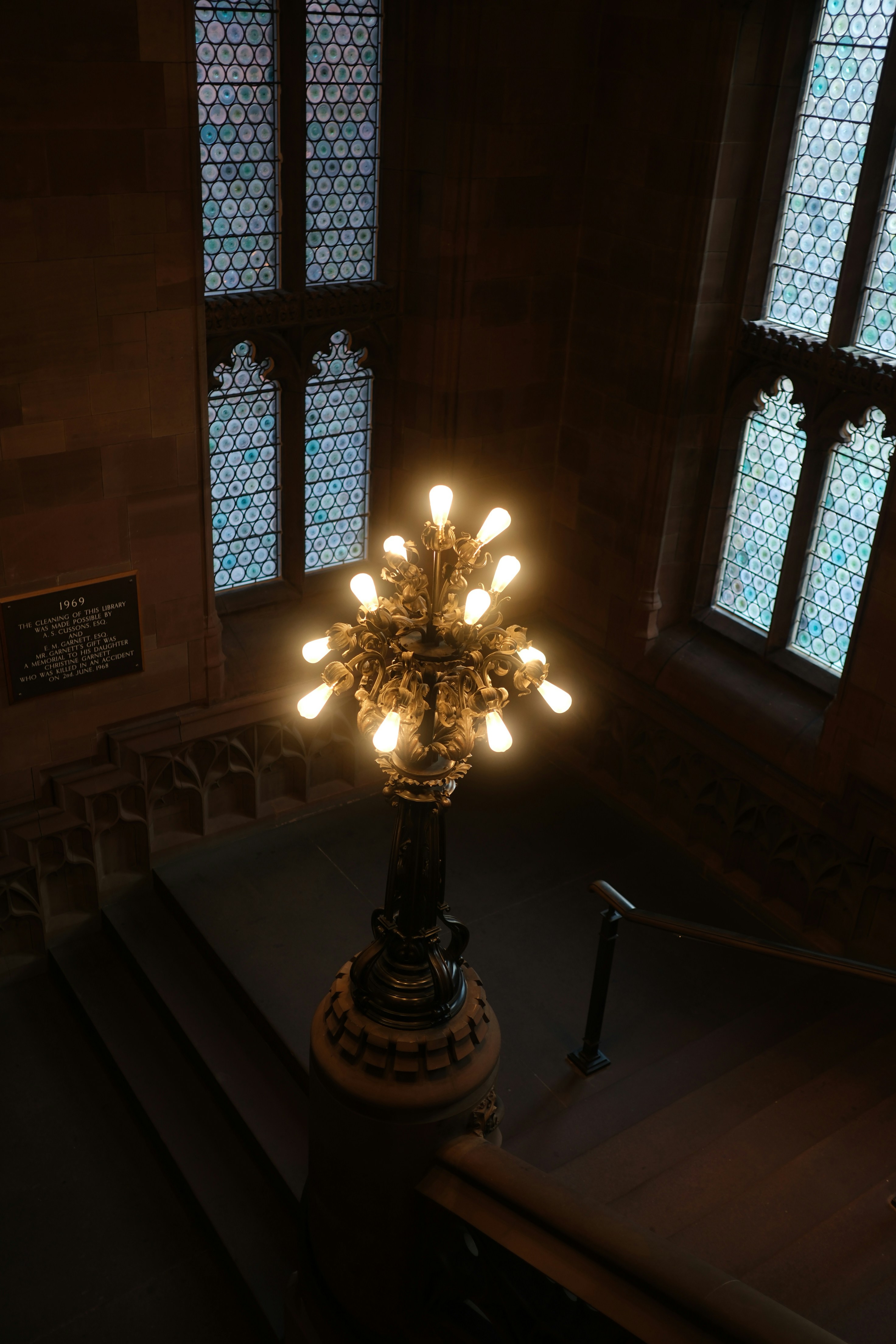 Ambient Glow: A Gallery Staircase Illuminated by a Ornate Central Lamp