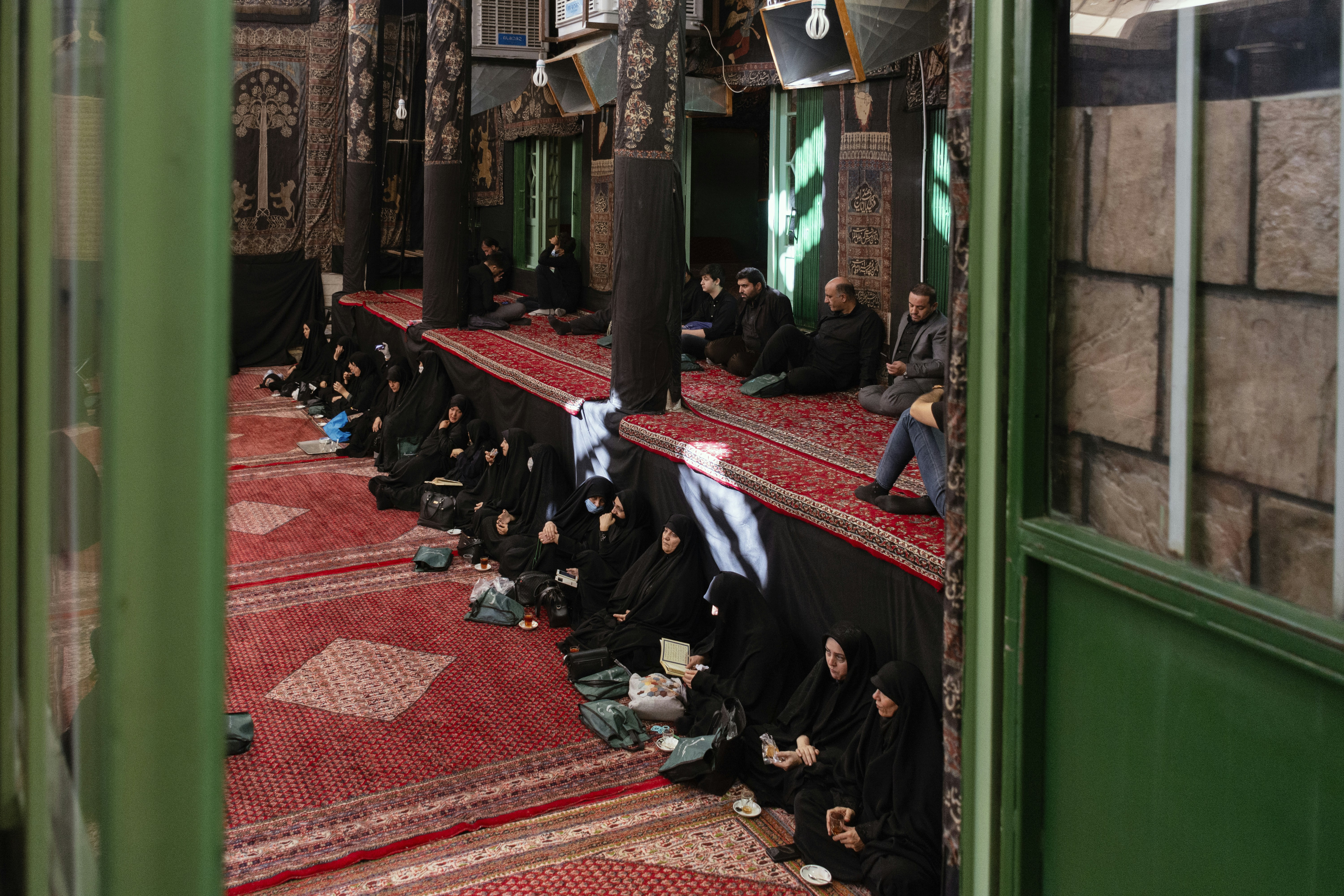 Niche Prayer Hall: Women in Black in a Red Carpeted Courtyard