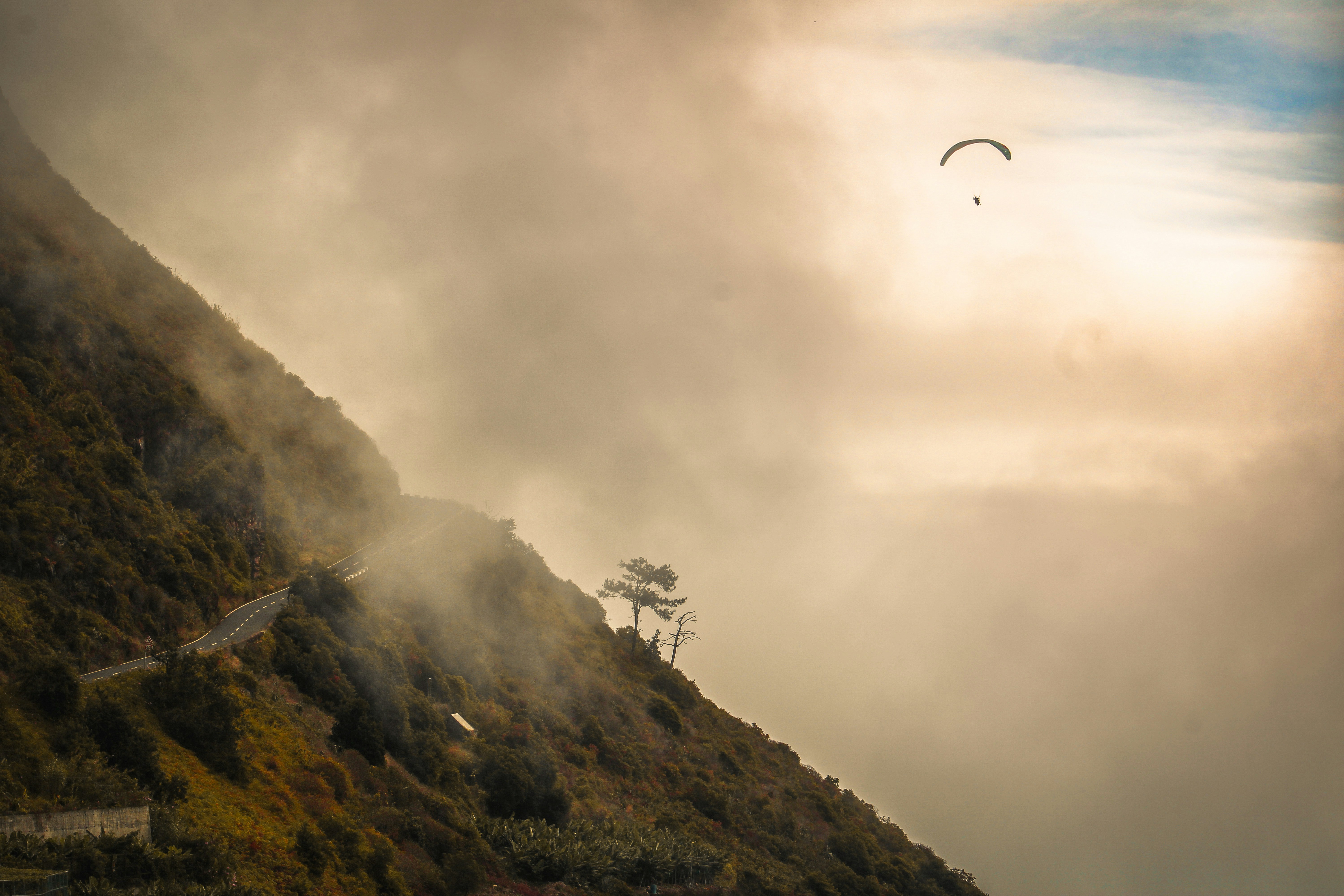 Cloudbound Paraglider over a Quiet Mountain Road