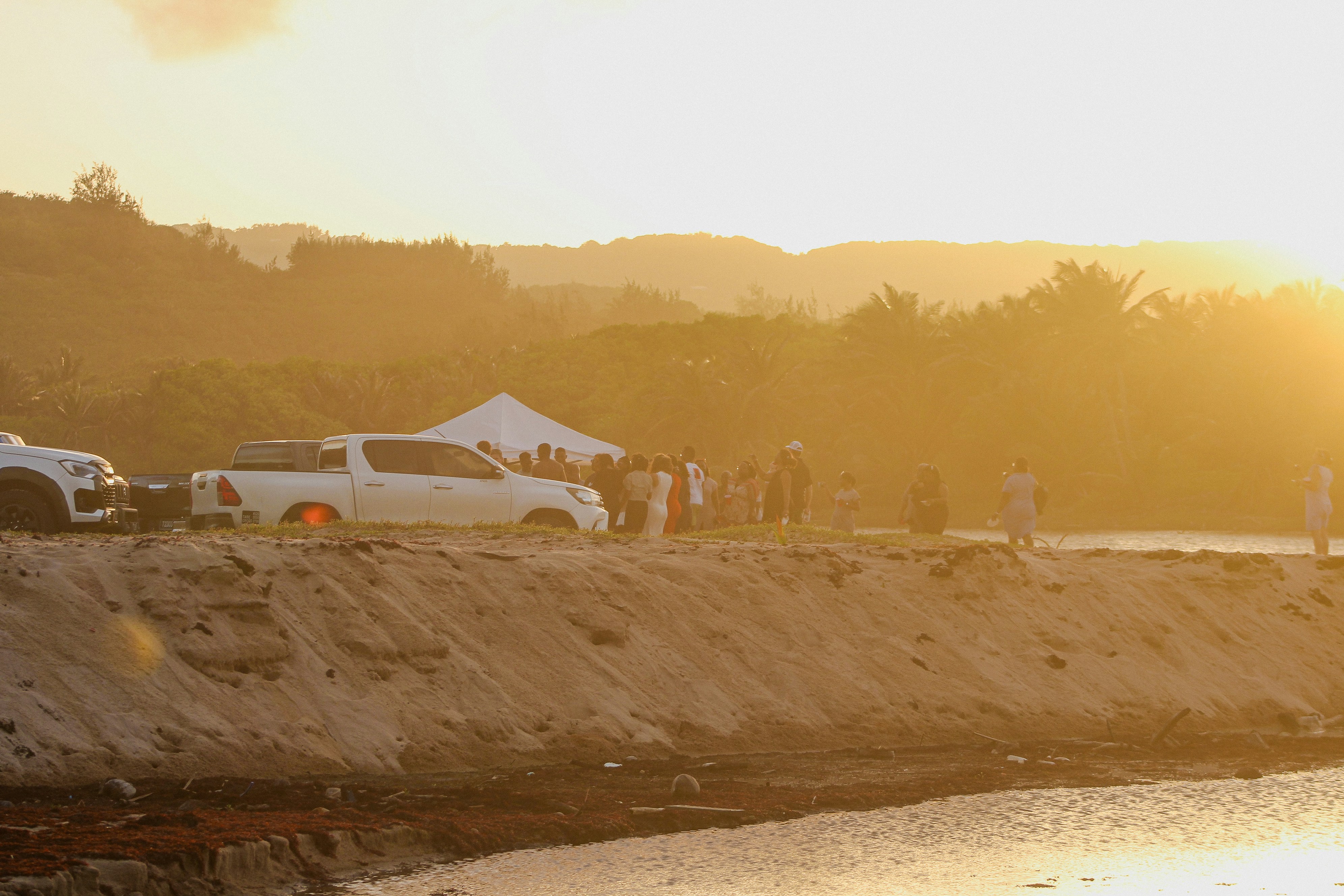 Sunset shoreline gathering near a work-in-progress beachfront