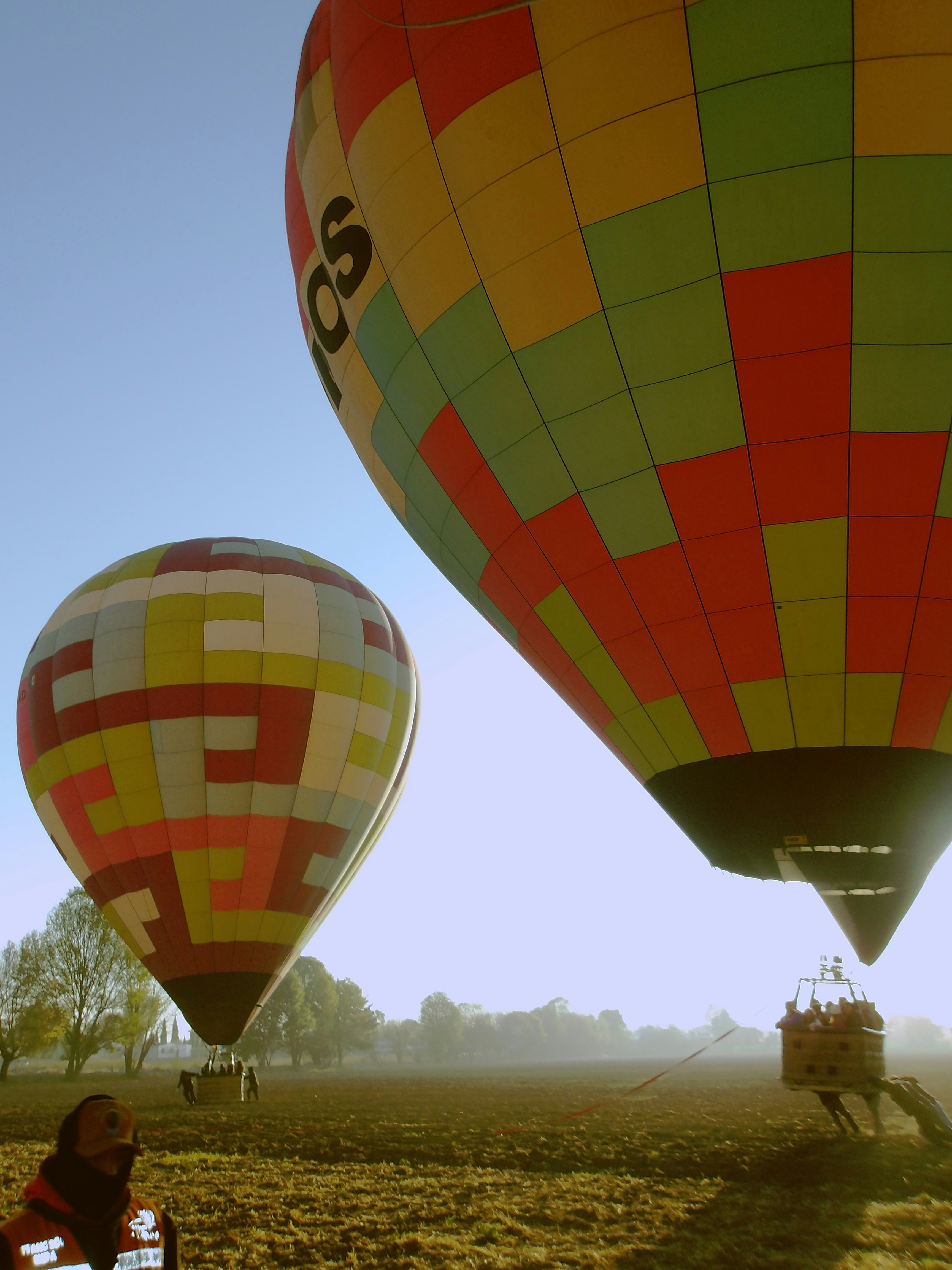 Two colorful hot air balloons on a field