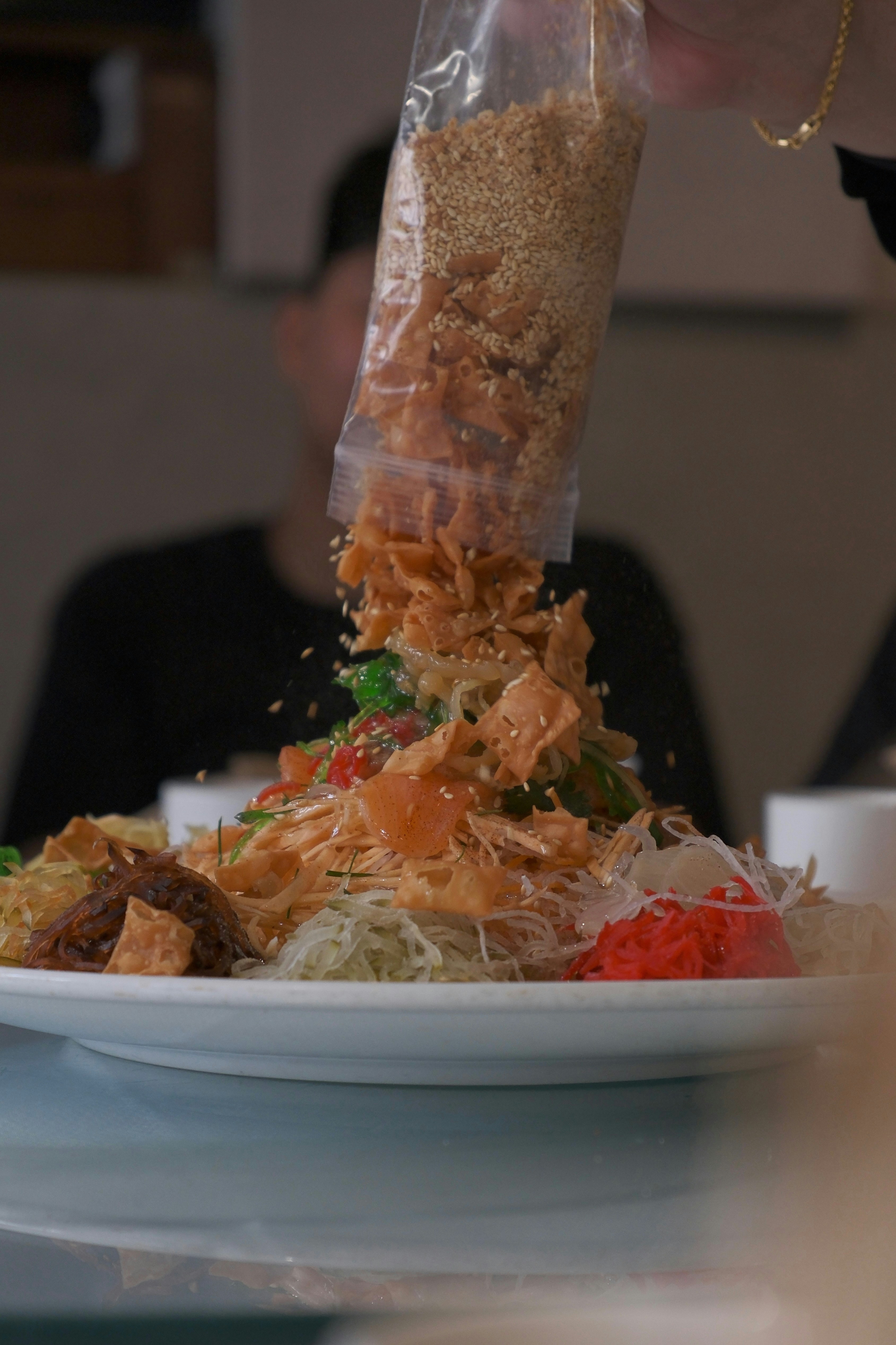 Graceful Toss: Crispy Garnish Cascade into a Plate