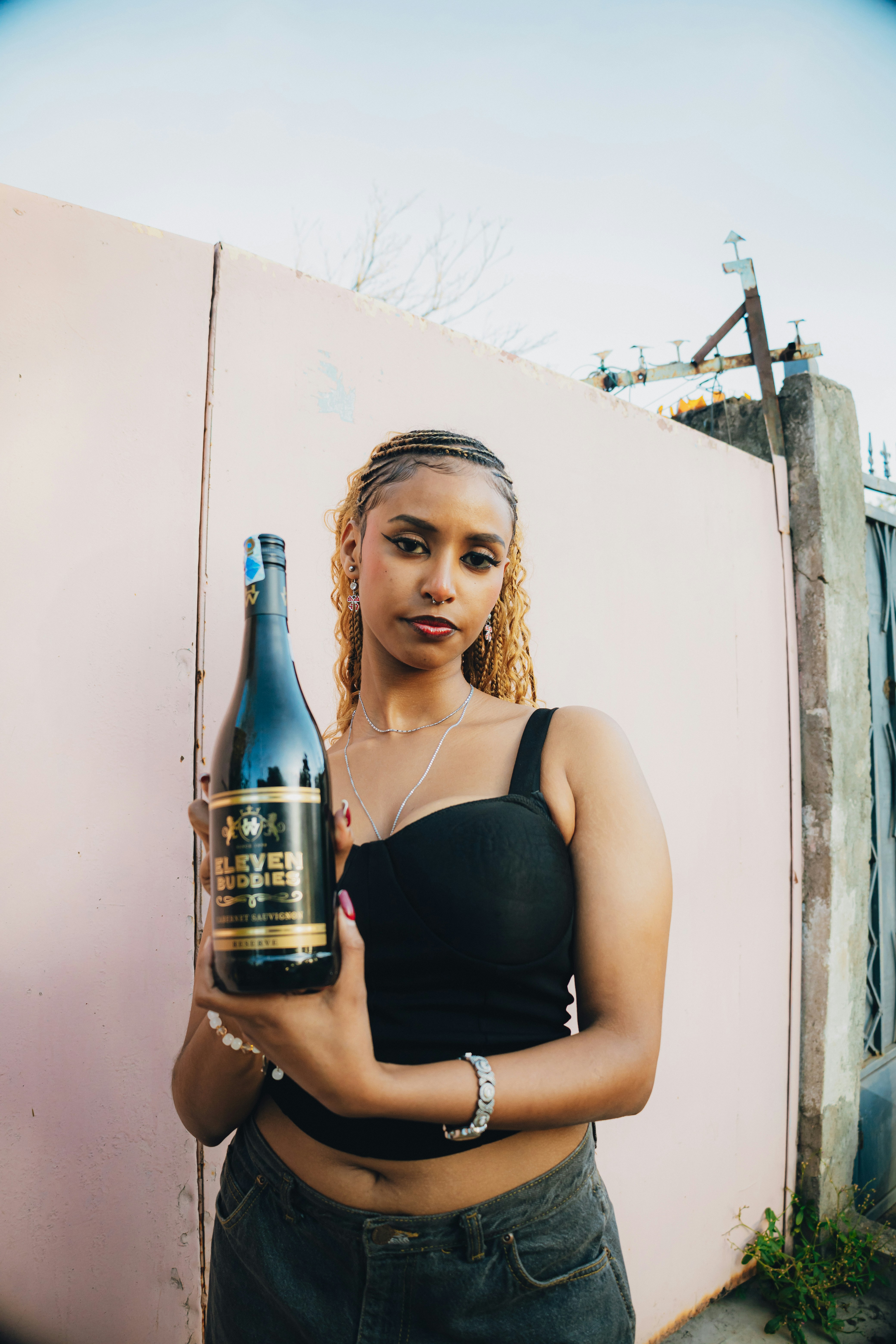 Bottle in Focus: A Confident Portrait against a Soft Pink Wall