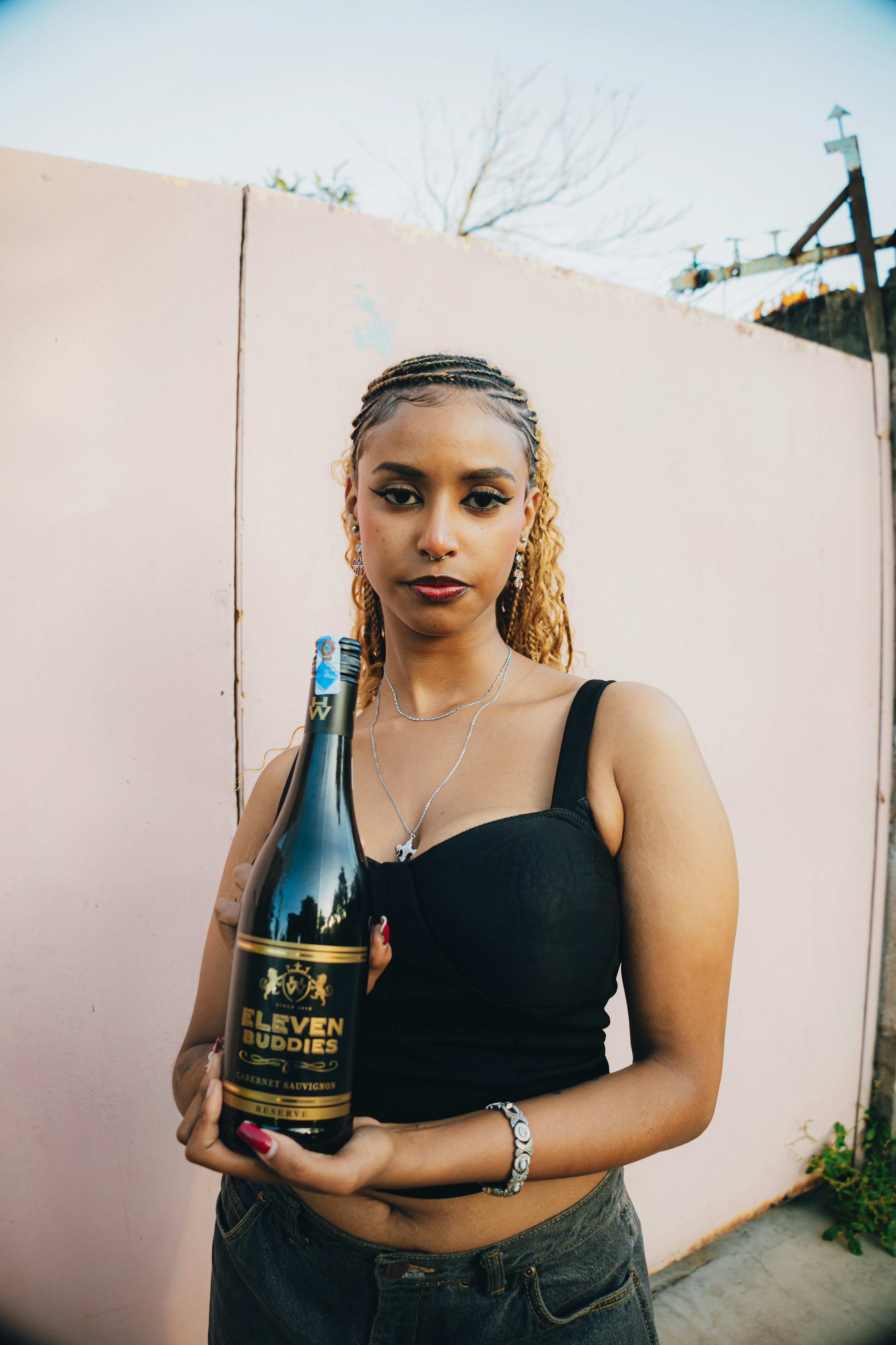 Portrait with Champagne: A Bold Moment Against a Soft Pastel Wall