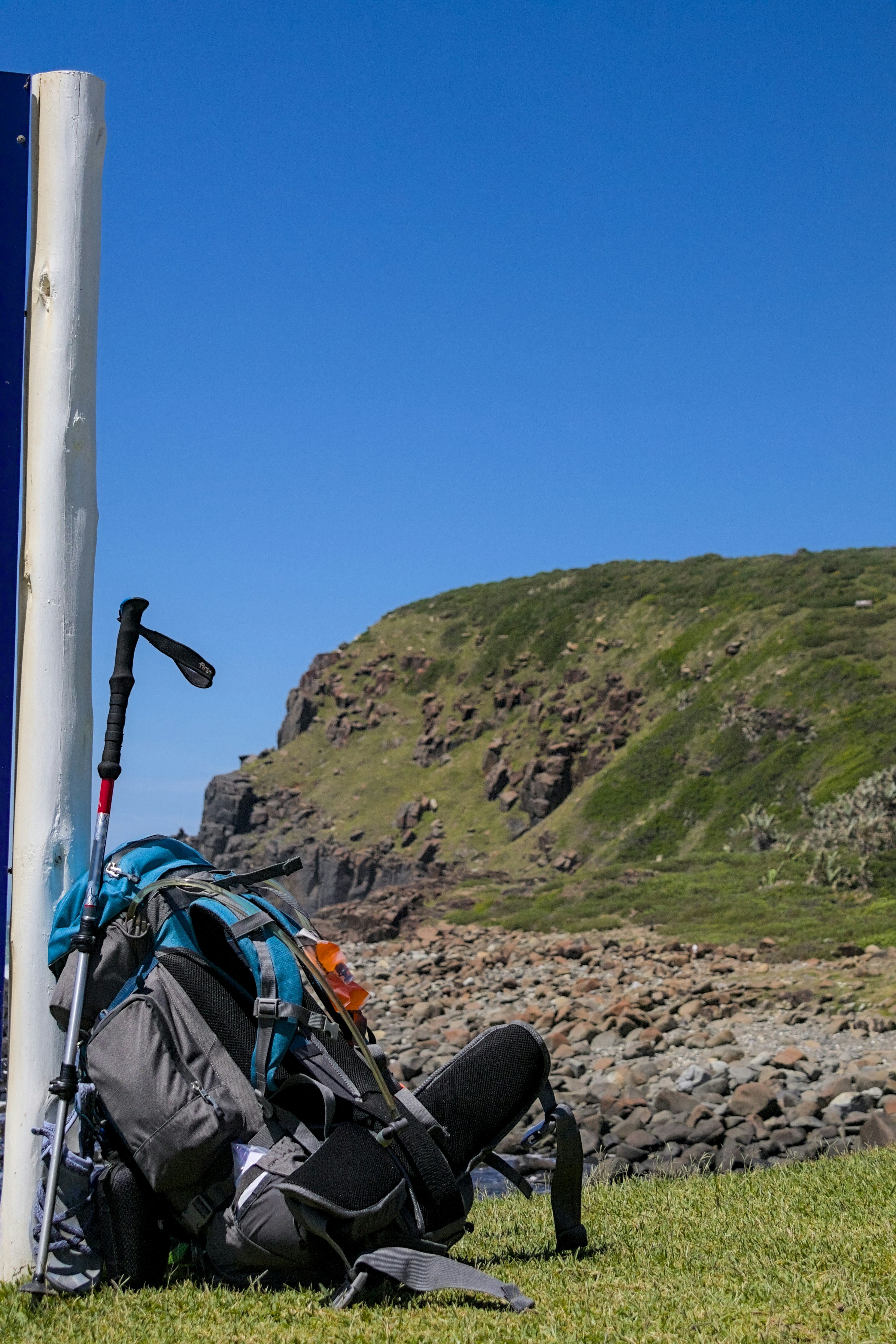 Coastal Gear at the Edge: Backpack Leaning by the Cliff