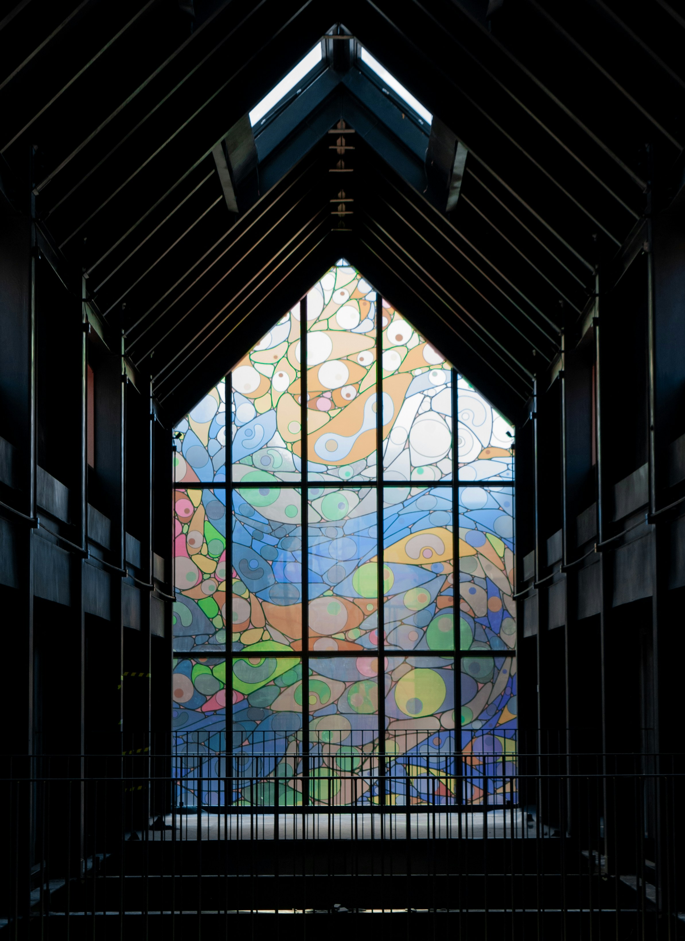 Colored Glass Cathedral: Light Through Abstract Panes in a Dim Corridor