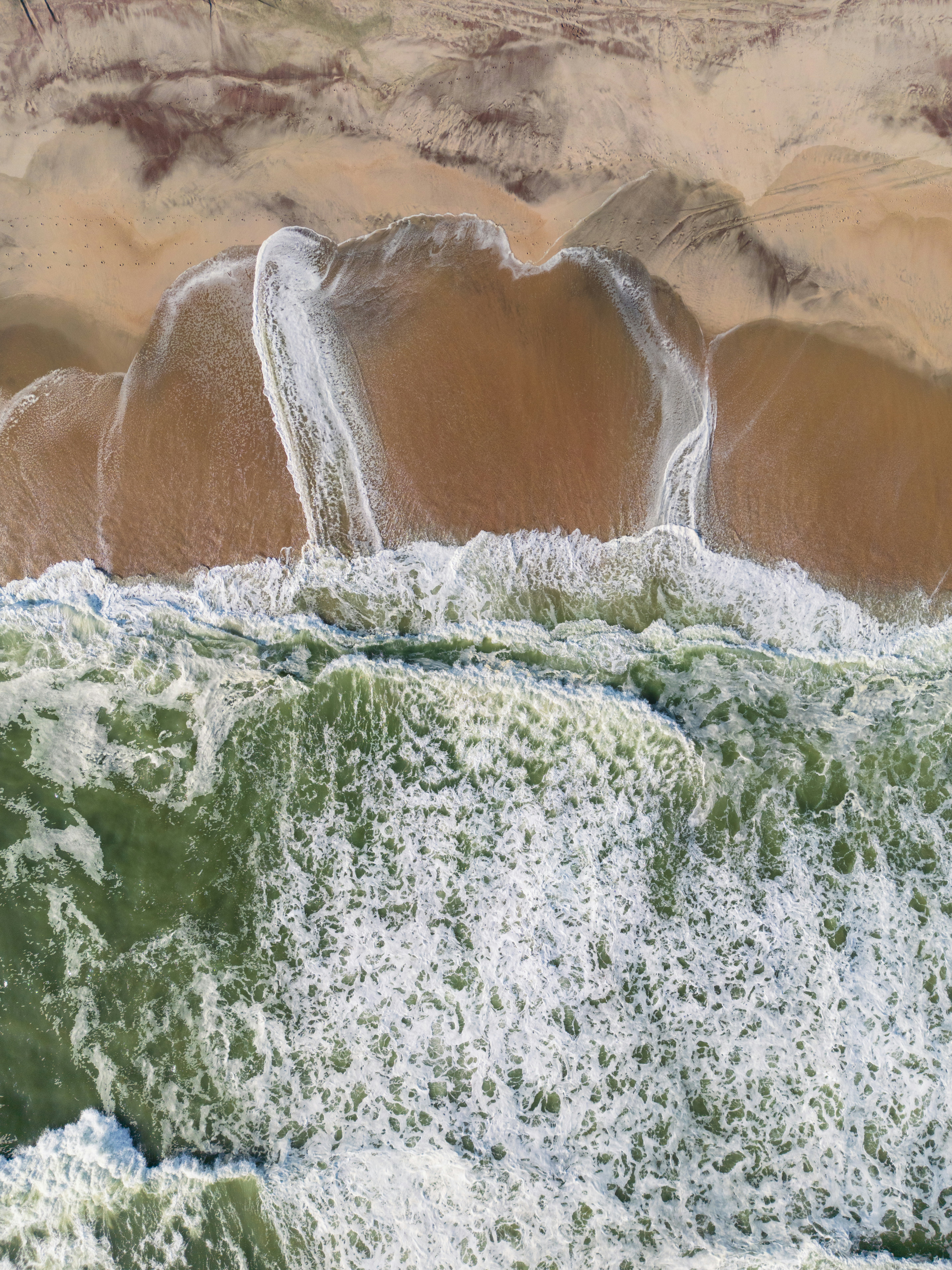 Aerial Break: Curtain of Turquoise and Foam over Sandy Shore