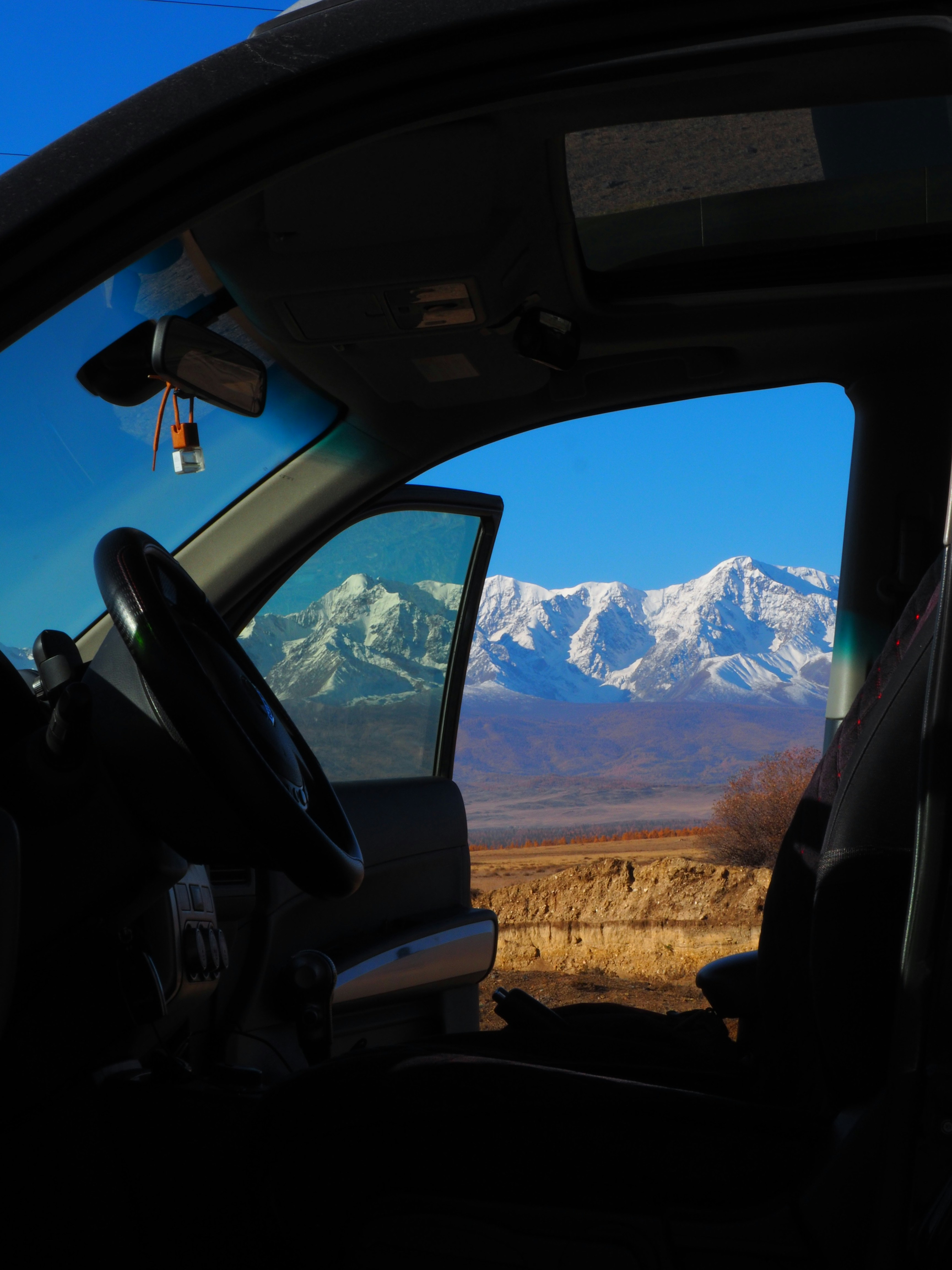 Deserted Cabin View: Mountains Framed by Open Car Door