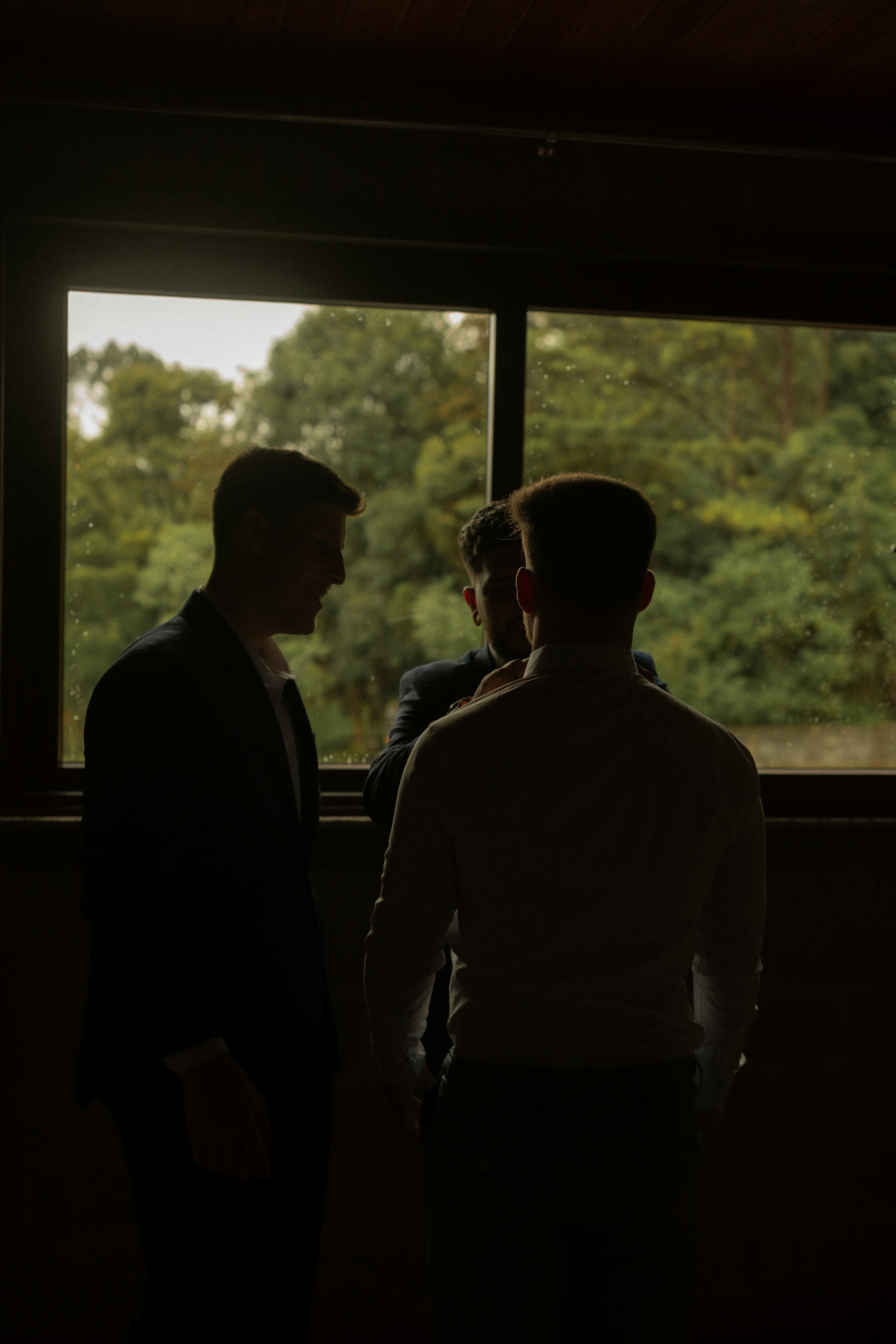 Mid-Conversation Silhouettes in a Sunlit Window Frame