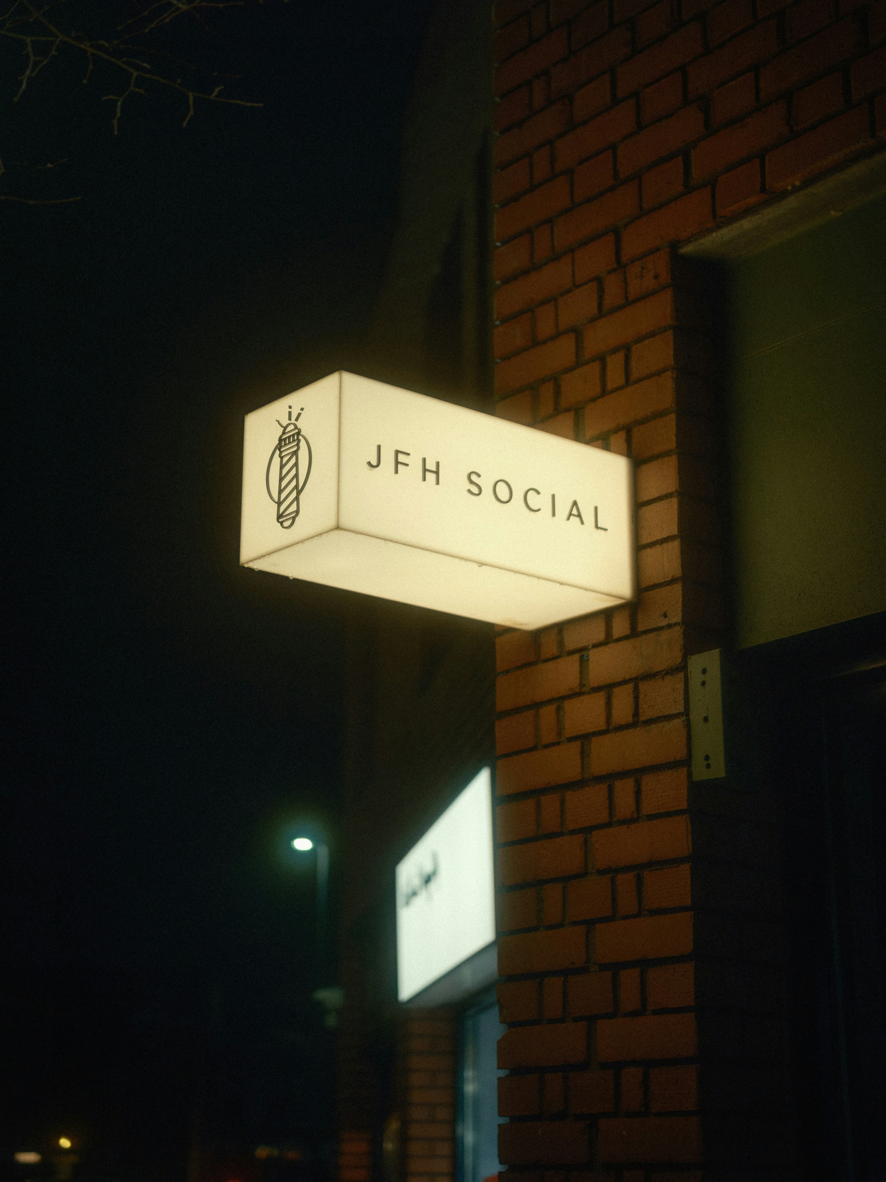Night Signage: The Glow of JFH Social Above the Brick Wall