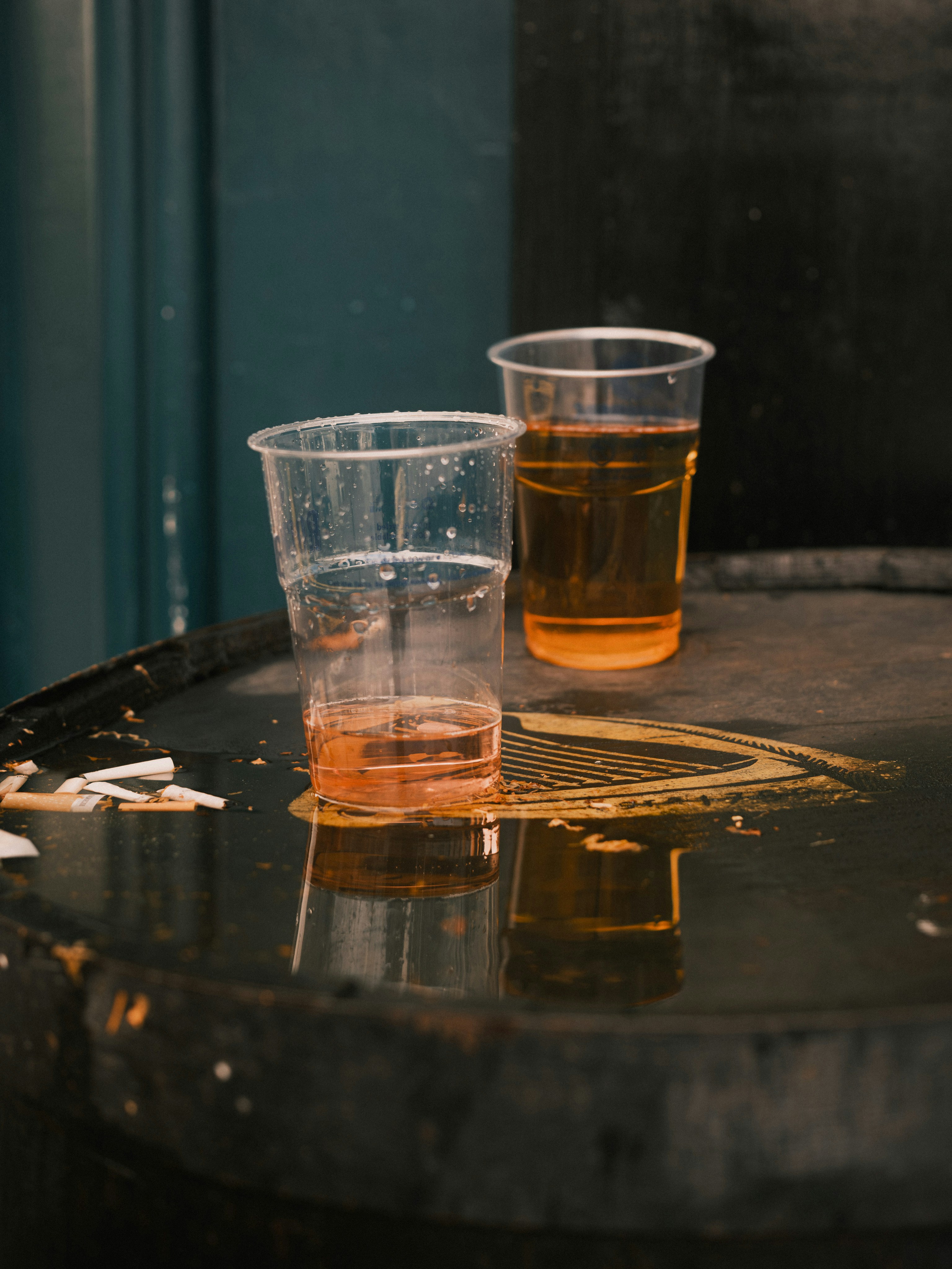 Two Angled Pours: Amber Liquids Reflect on a Weathered Barrel