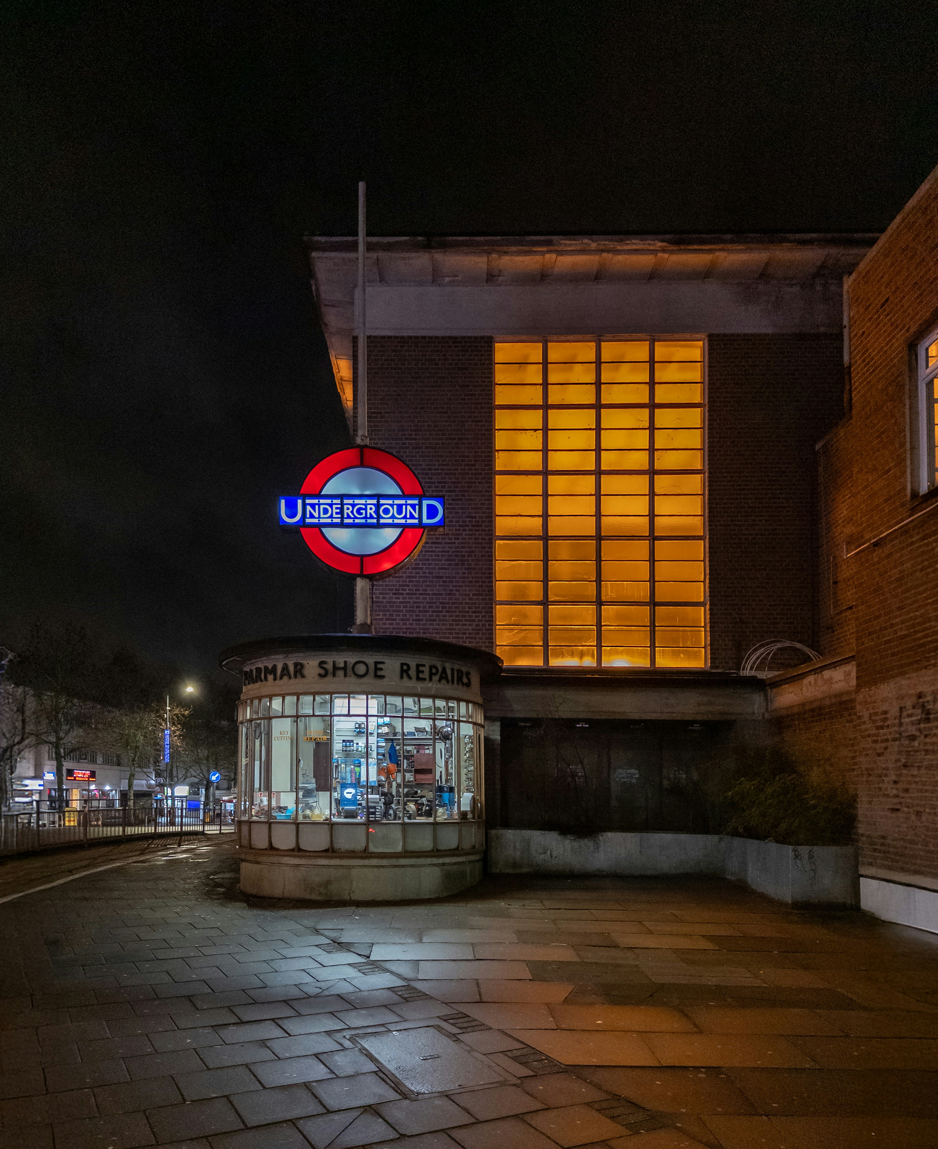 Night at the Underground Arcade: A Quiet Shoe Repair Stand Bathed in Neon Glow