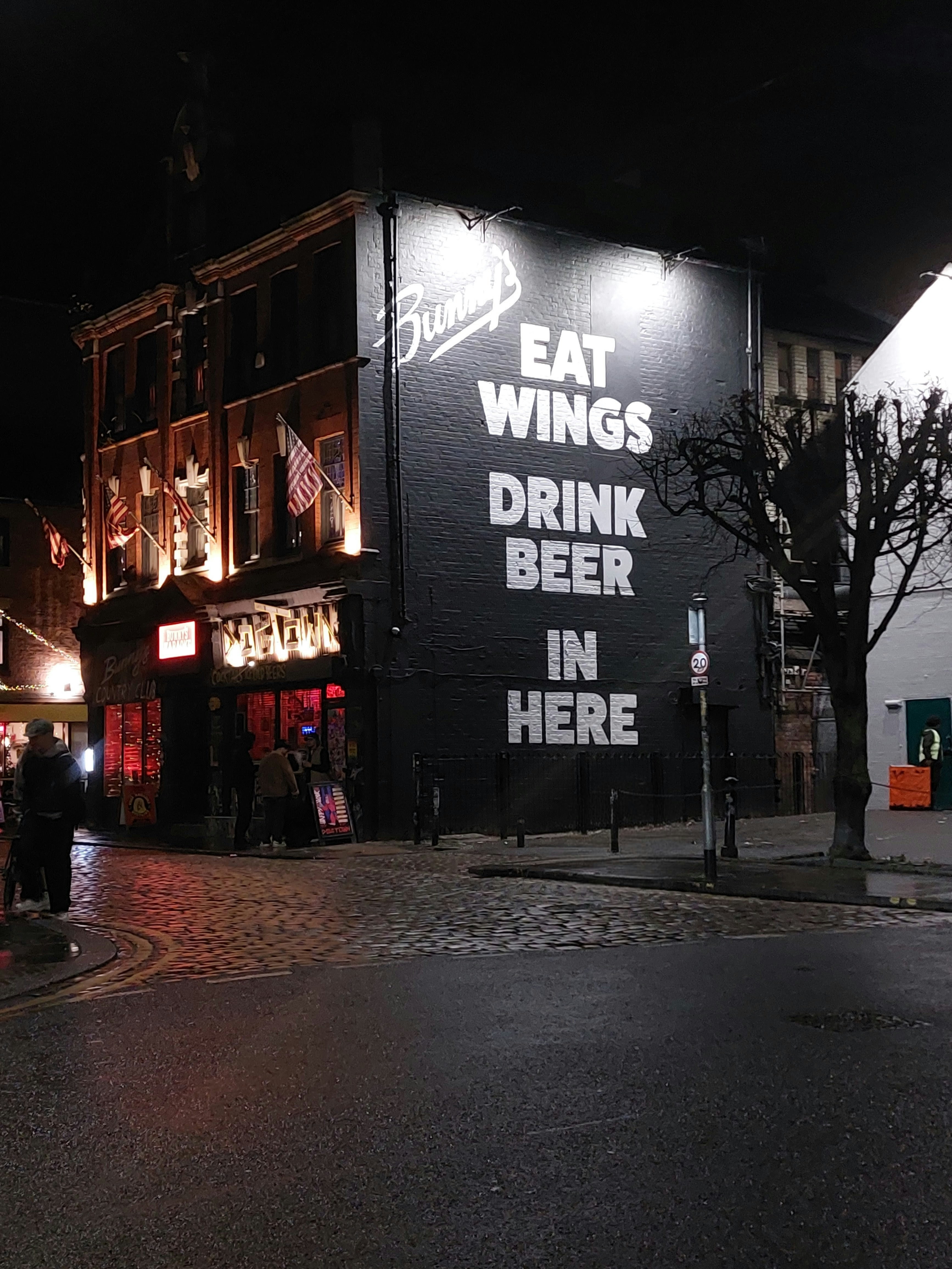 Neon-lit Corner: The Wall Ad with Eat Wings Drink Beer
