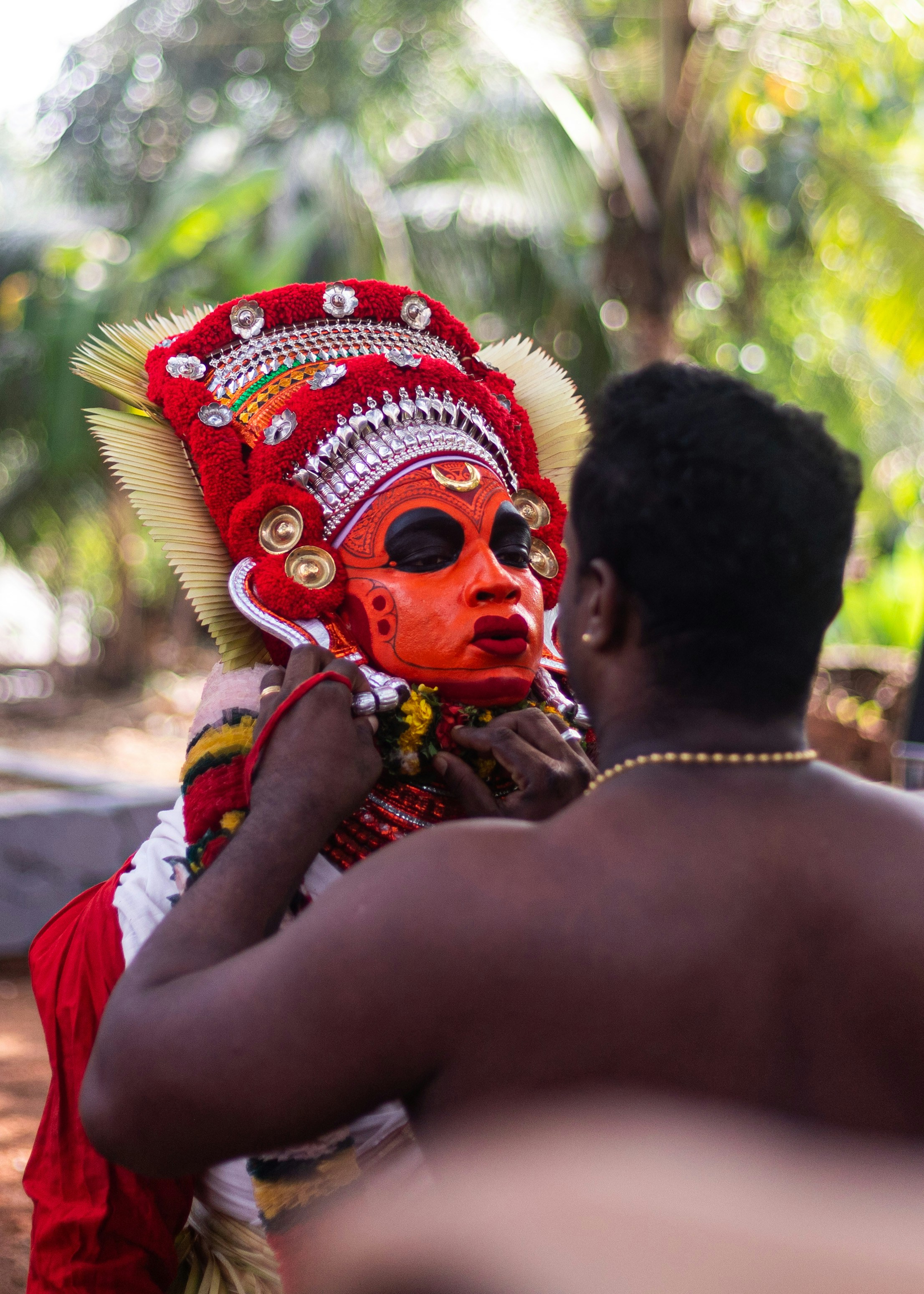 The painstaking preparation for the Theyyam festival in Kannur, Kerala is an art form in itself. Artisans and performers spend hours crafting elaborate headgear, hand-painting vibrant face masks, and assembling layered costumes with natural pigments, palm leaves, and intricate patterns. Every line and color is applied with ritualistic precision, transforming the performer into a living deity. The slow, careful process reflects devotion as much as creativity, where tradition, mythology, and skilled craftsmanship blend to create the breathtaking visual splendor that defines the sacred Theyyam
