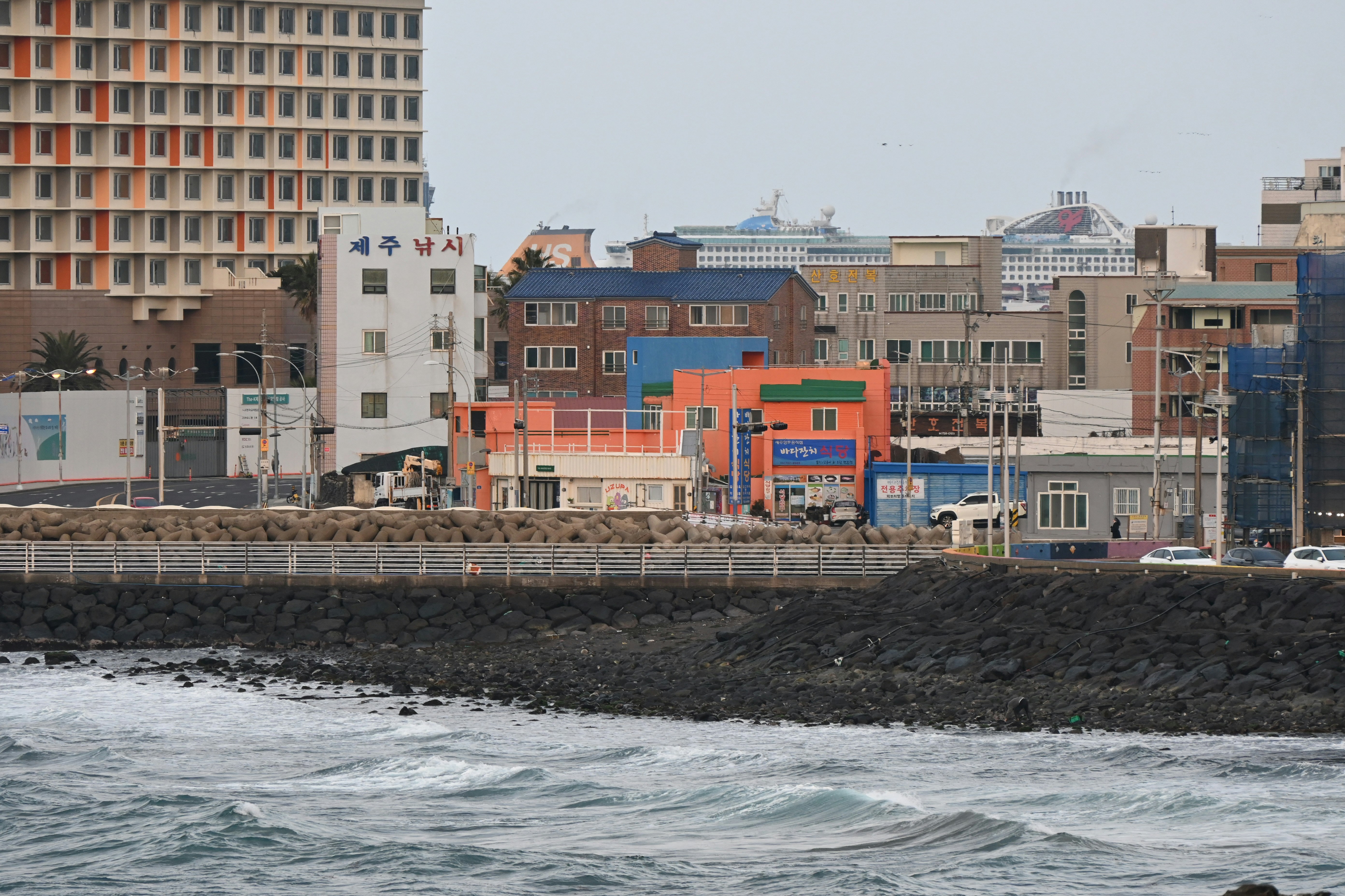 Coastal Row of Colorful Buildings Fringing a Rocky Breakwater