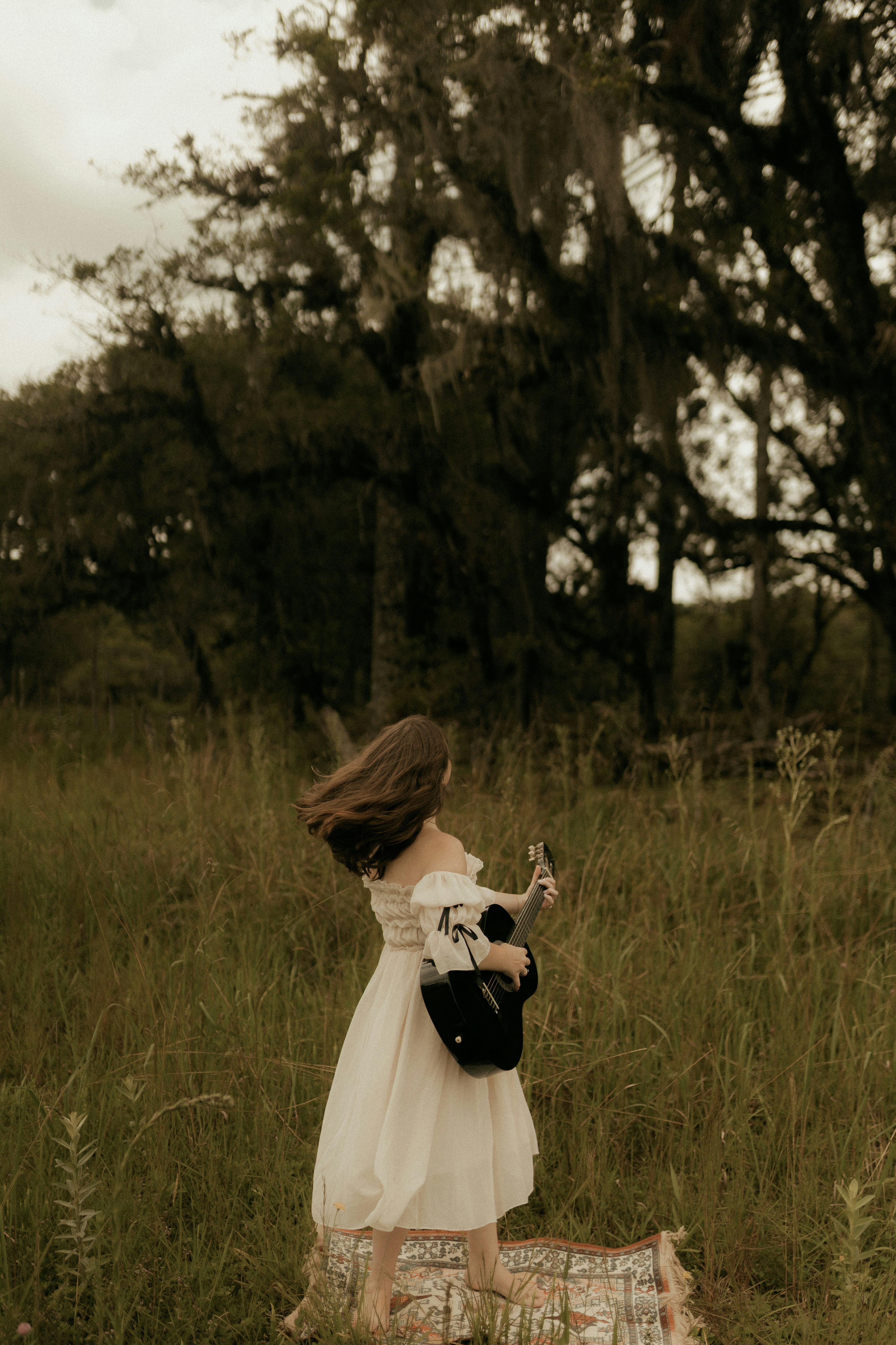 Guitar in the Wild: A Dressed Figure Wanders with a Soft Wind