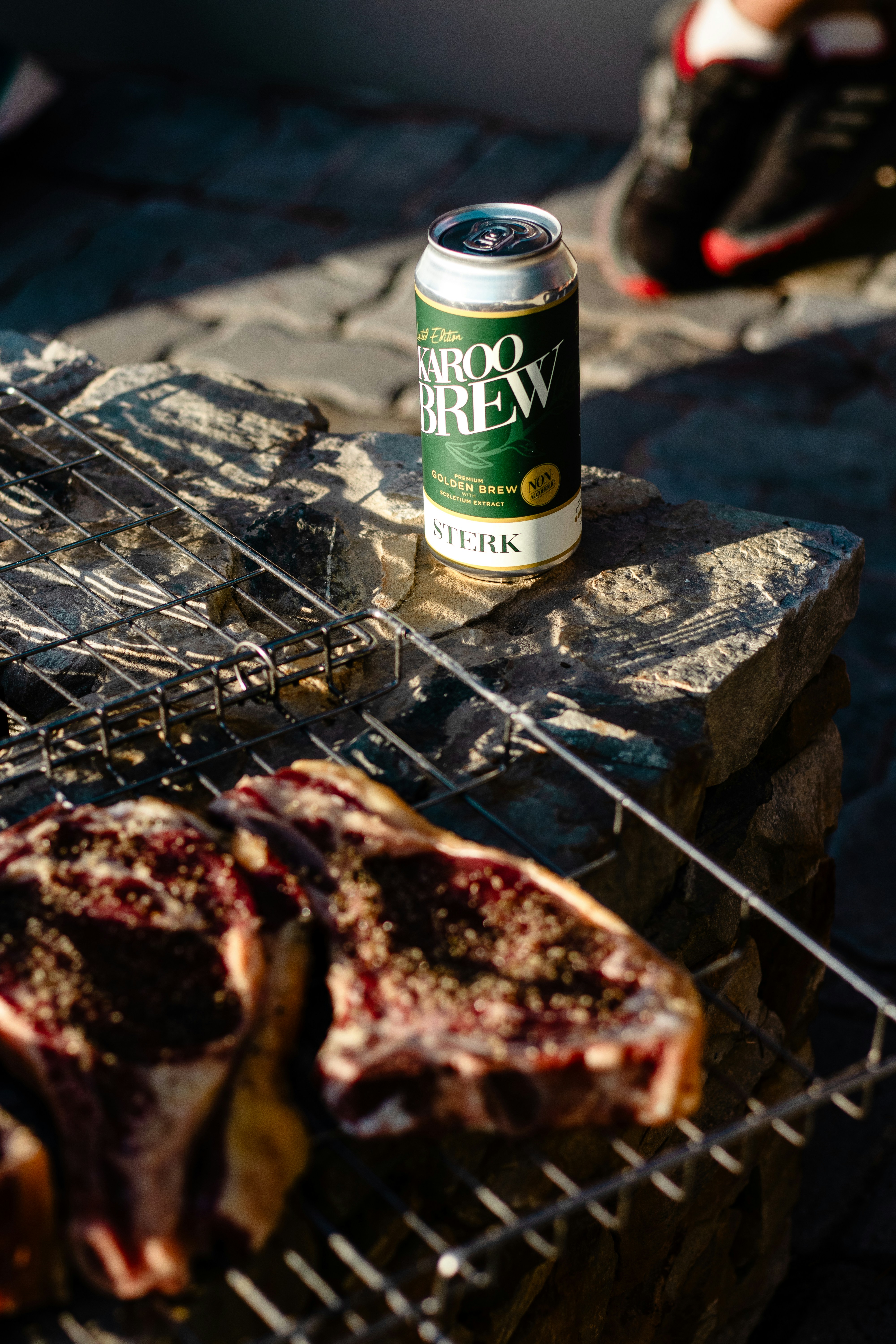 Sitting by the Grill: a Can of Kairoo Brew Watches Over the Charred Edge