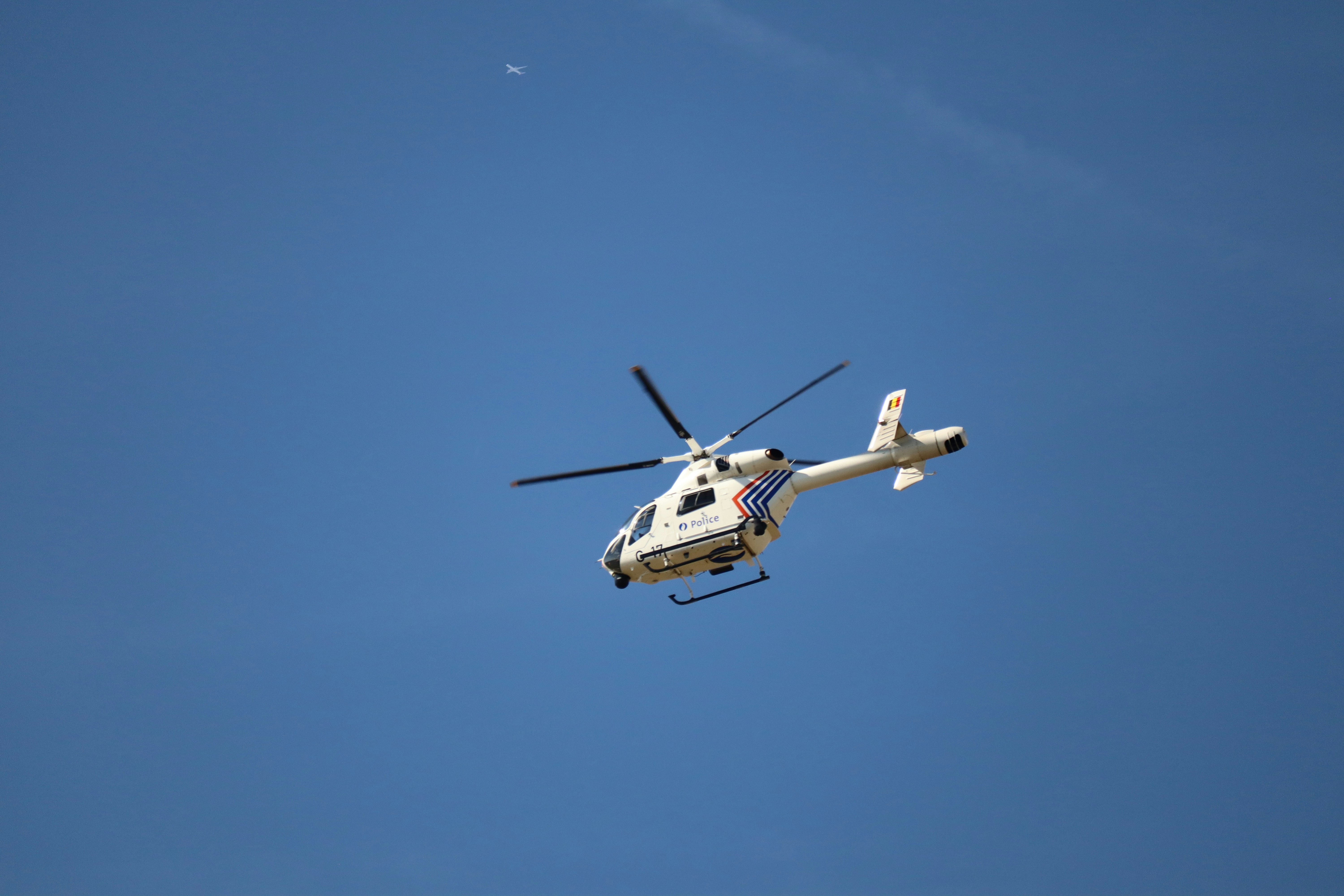 Aerial Liftoff: White Rescue Helicopter Trails a Clear Sky