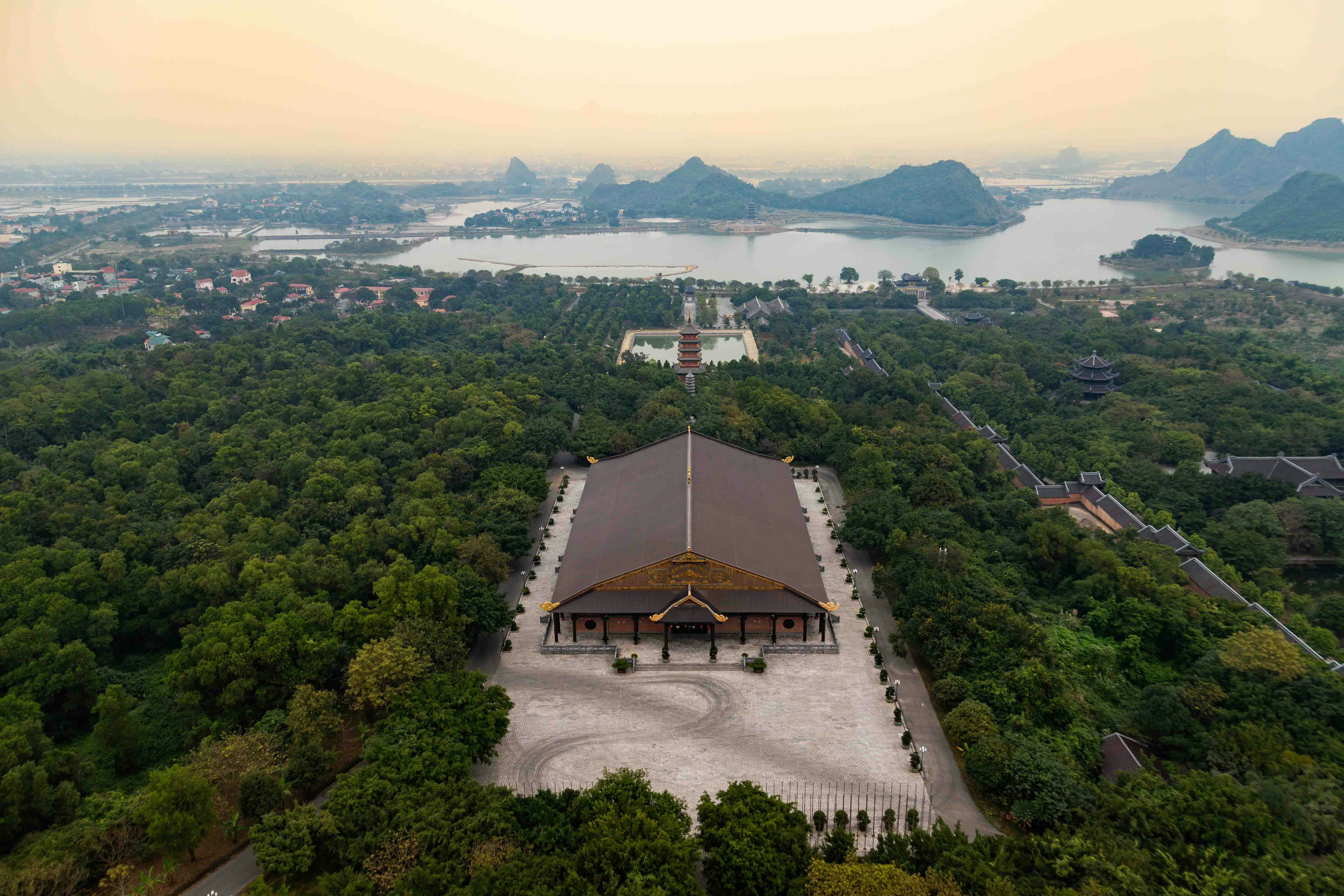 Temple Courtyard Amid Dense Forest Facing a Serene River Landscape